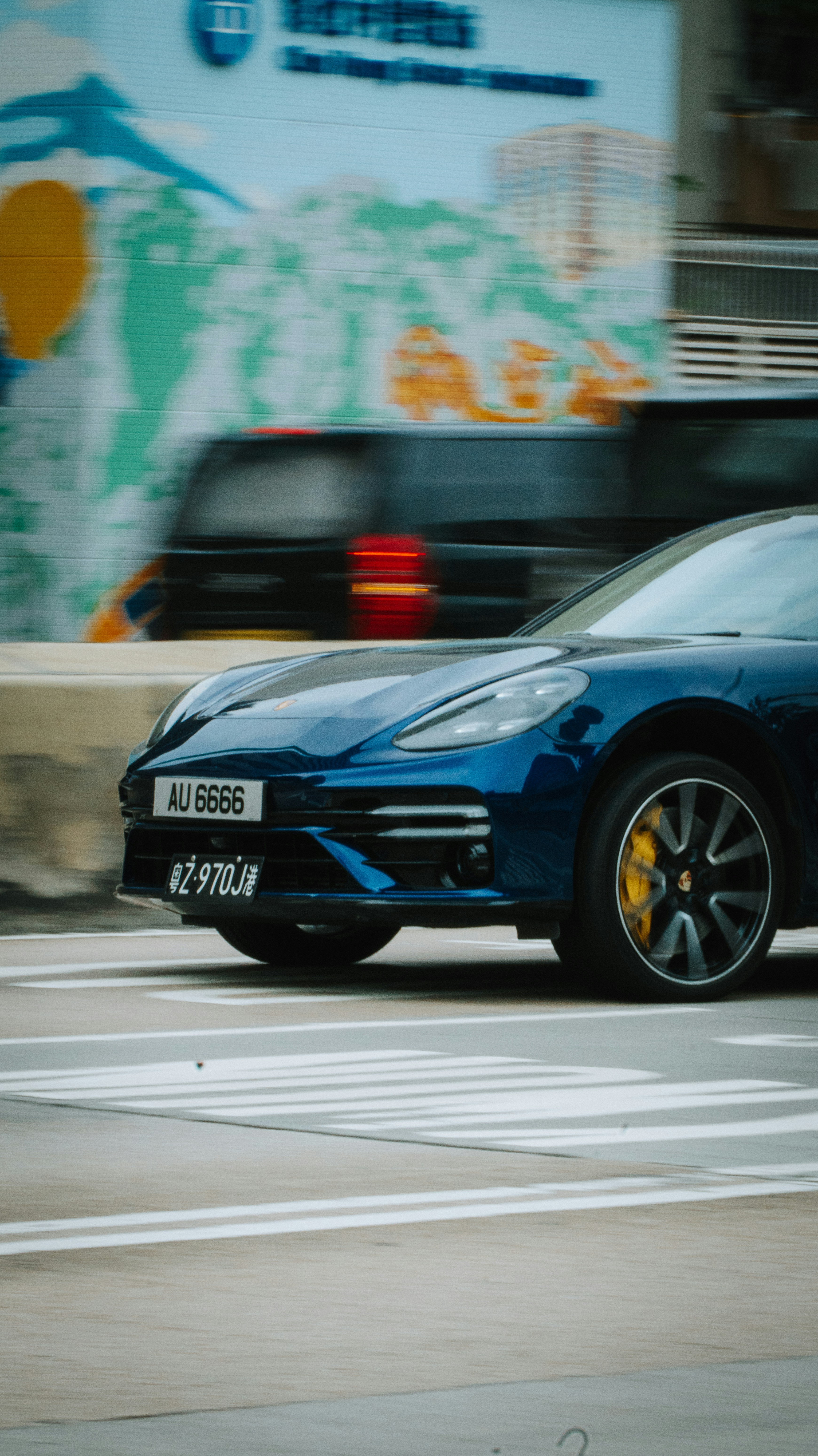 Blue Porsche in Motion Through a City Mural