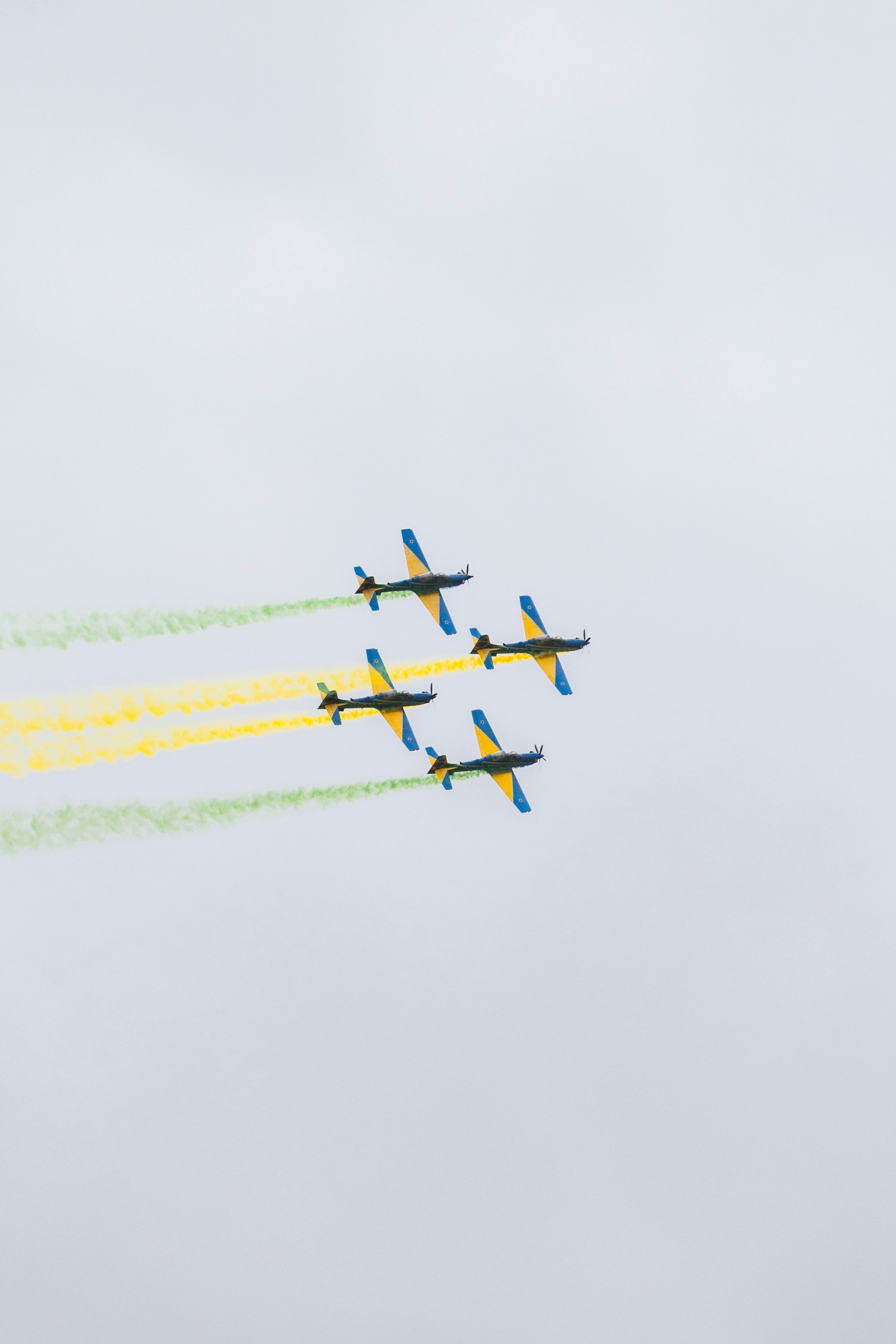 Rainbow Formation: Four jets carve colored trails in a pale sky