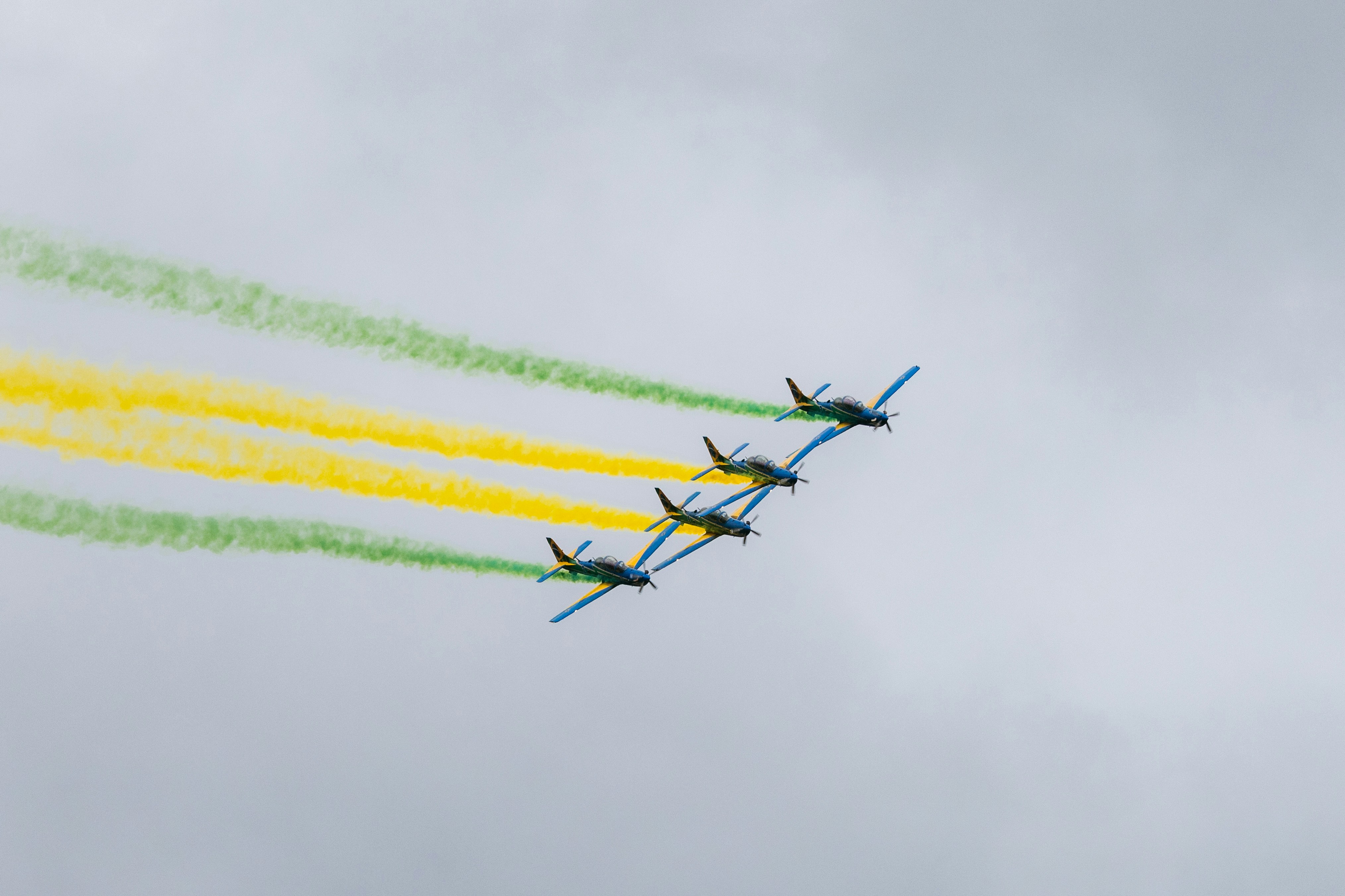 Blue Arrow Quartet: Green and Gold Smoke Trails Across a Gray Sky