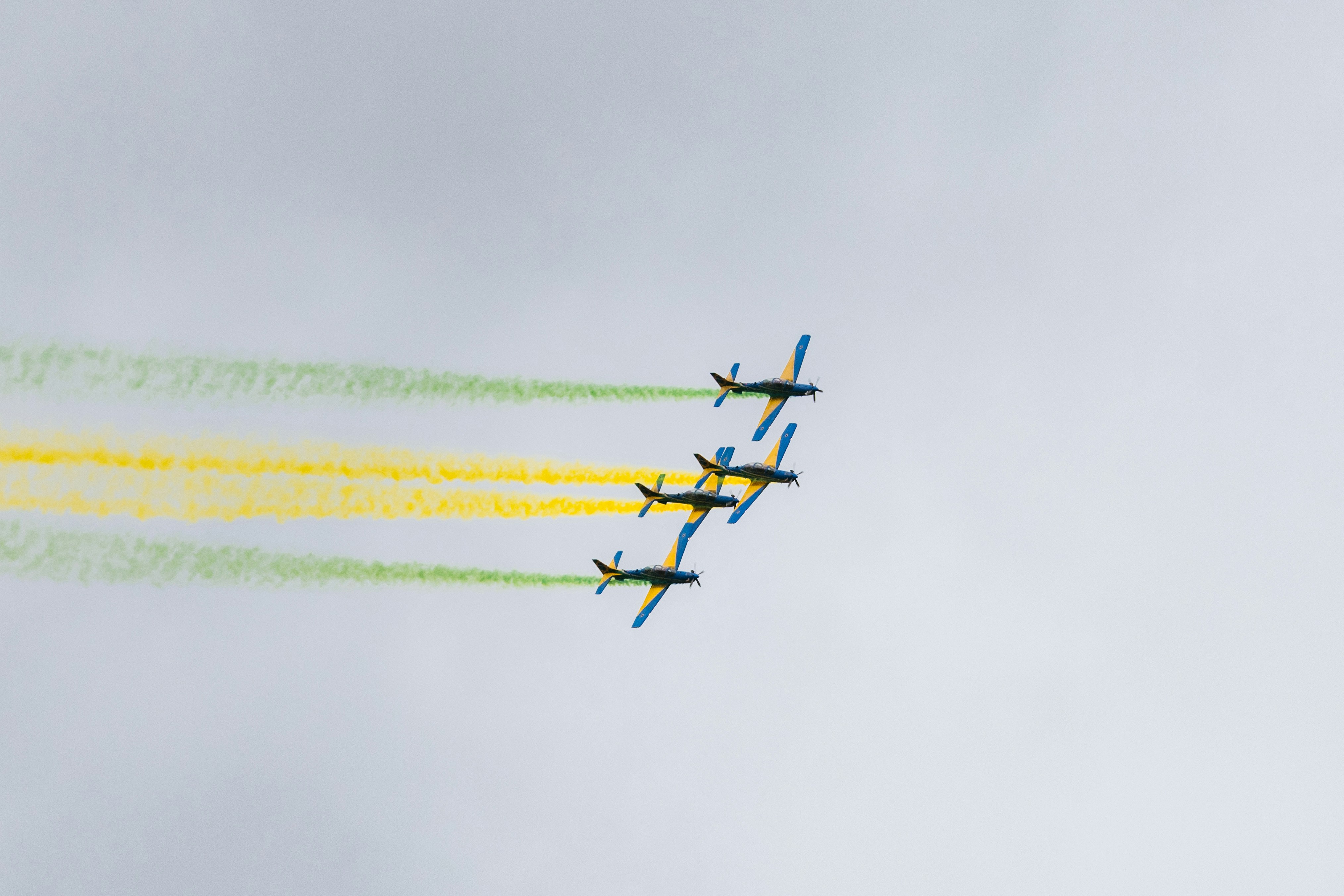 Vapor Spectacle: Four jets etch colored trails across a pale sky