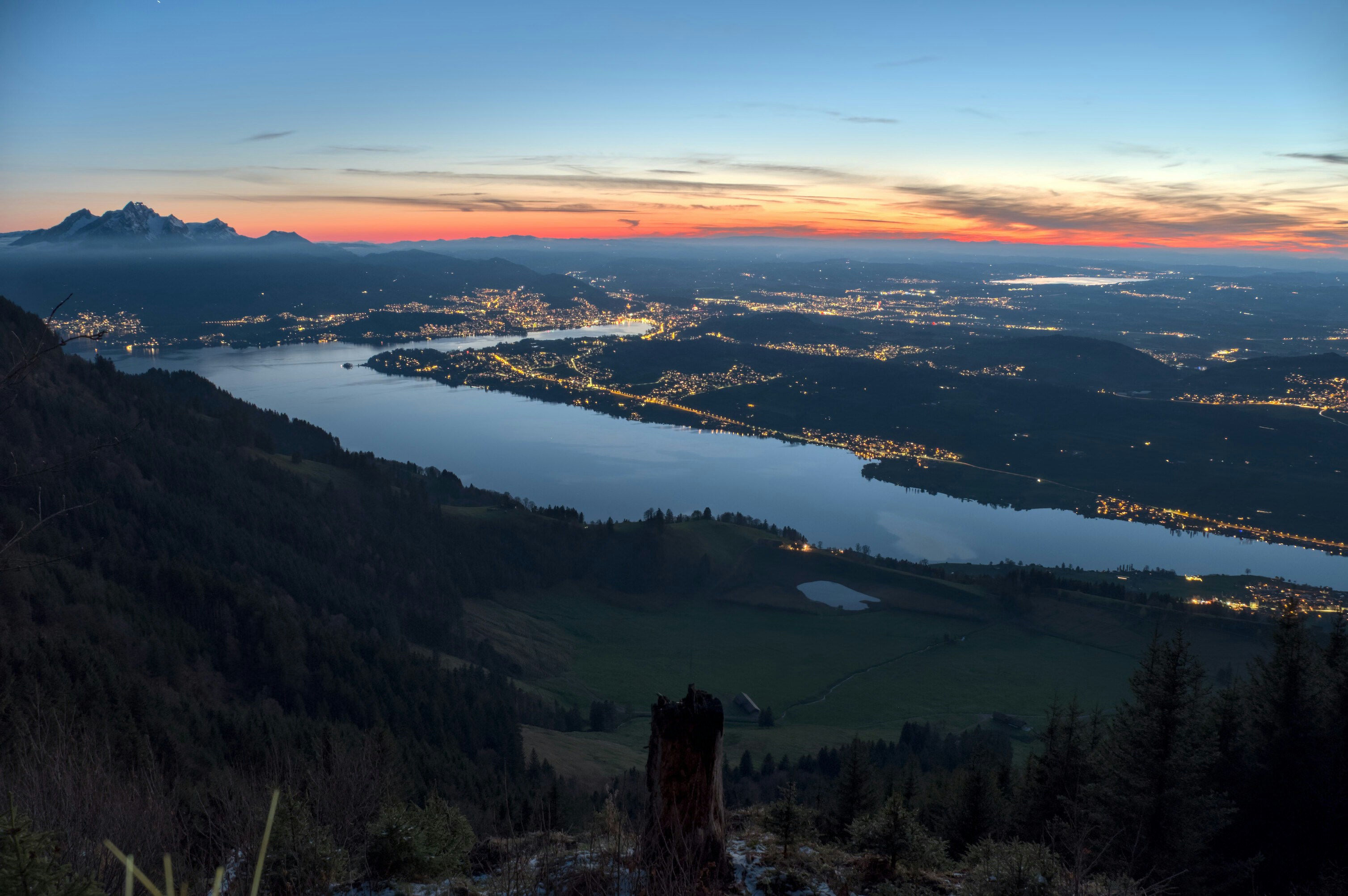 Dusk Ribbon: City Lights Unfurl Along the River Valley