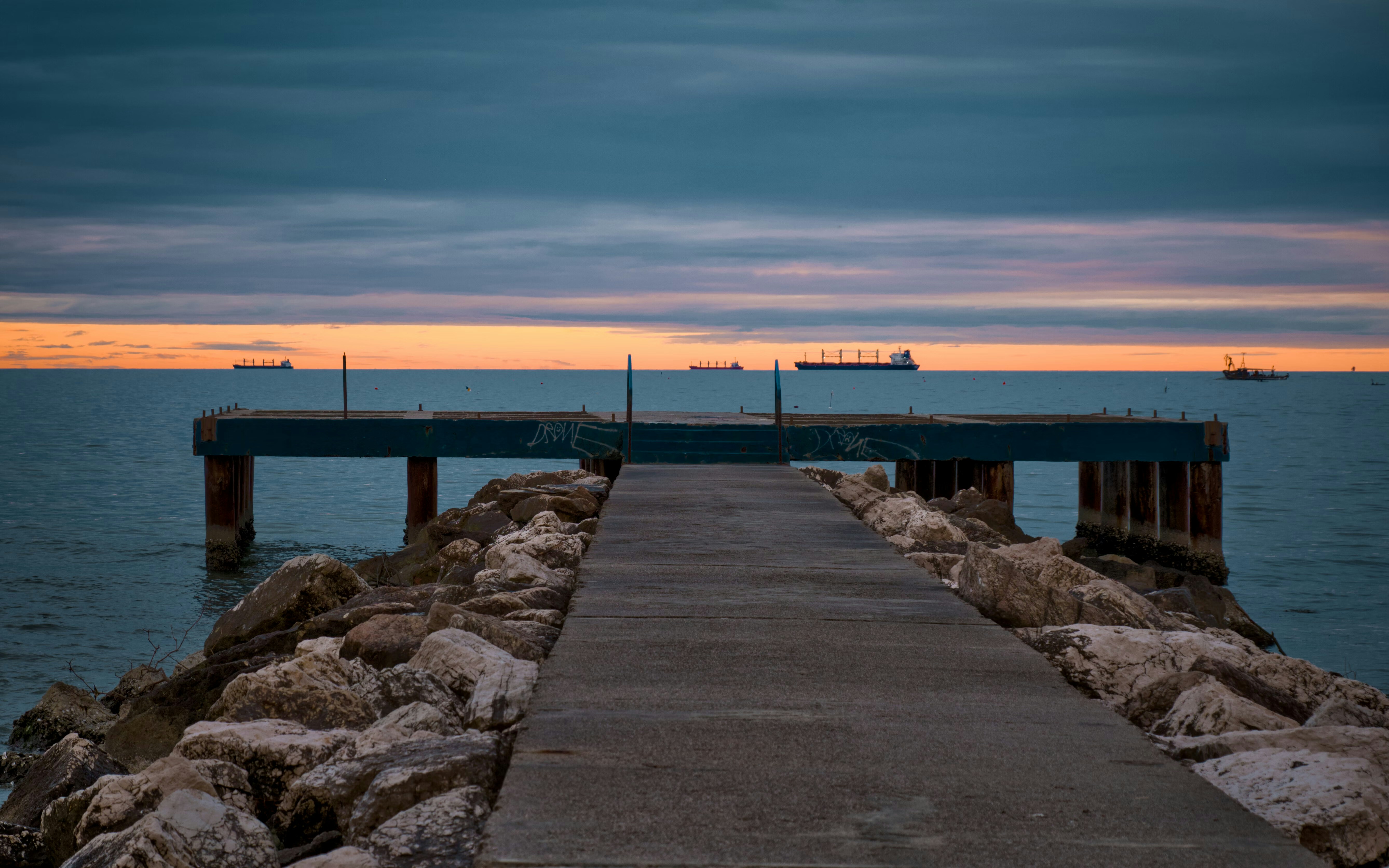Jetty to the Silent Horizon: Ships Drift on Sunset Sea