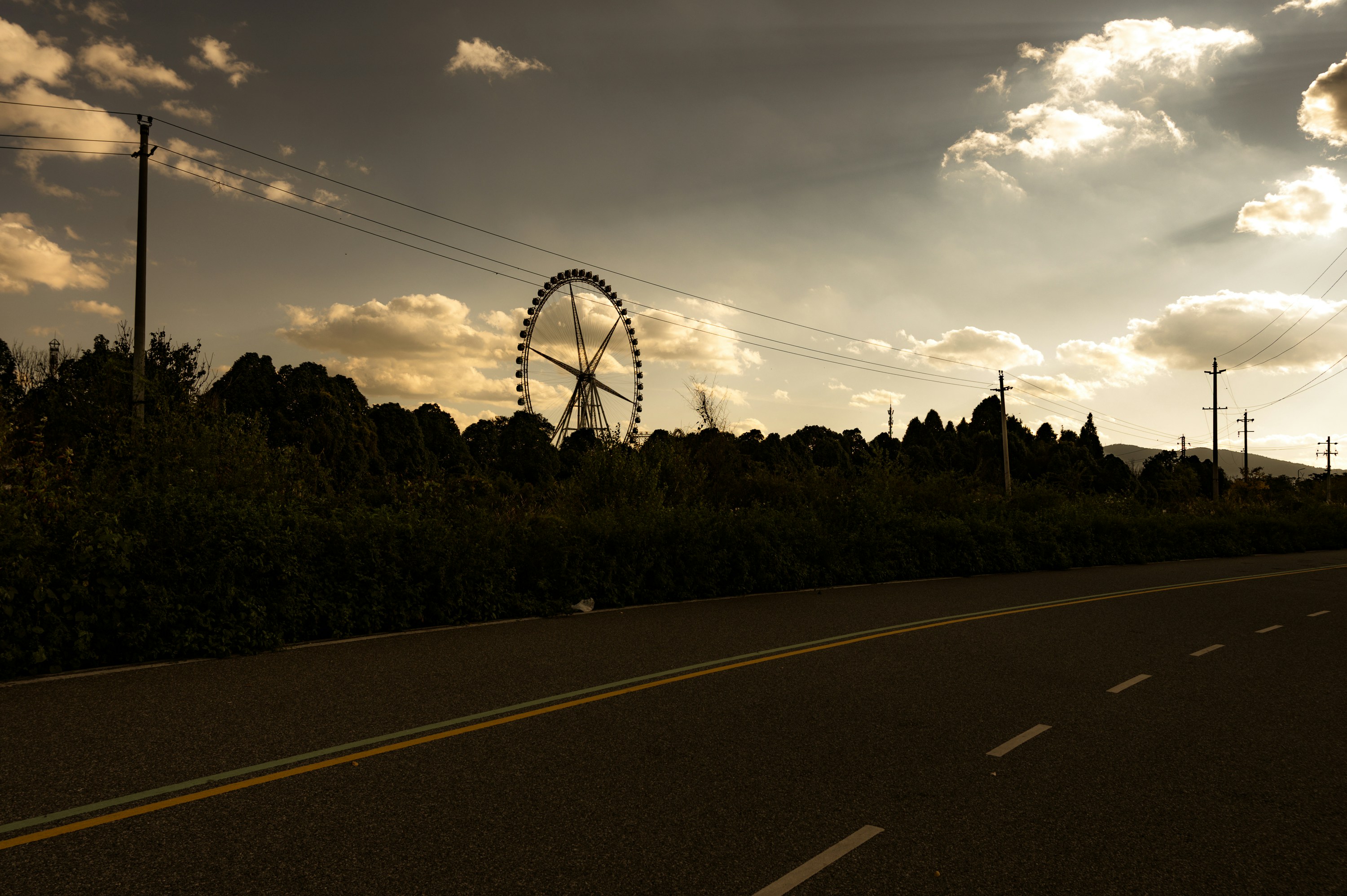 Ferris Wheel on the Horizon: Dusk Over an Empty Highway