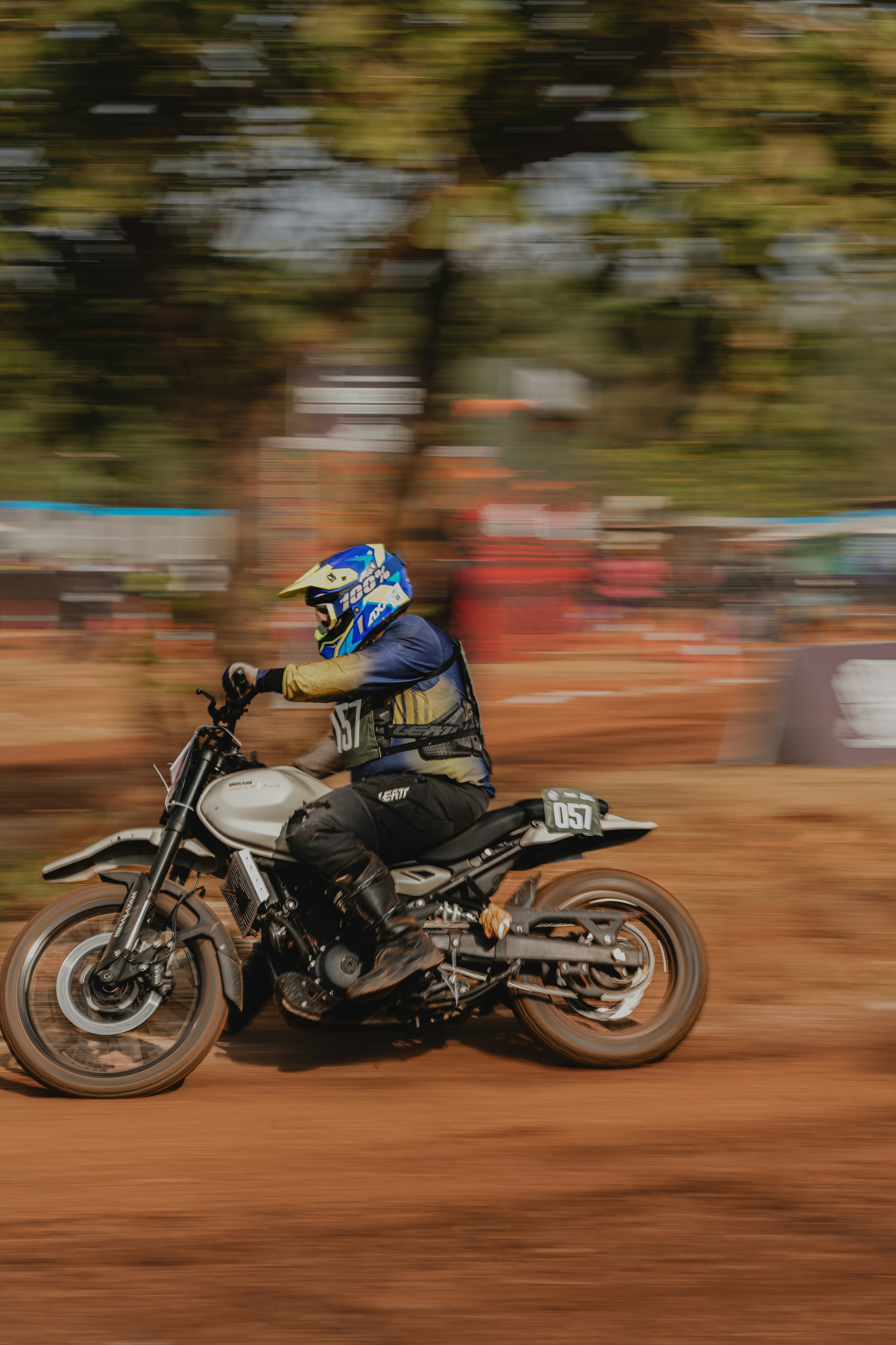 Blue-Helmet Sprint on a Muddy Dirt Track