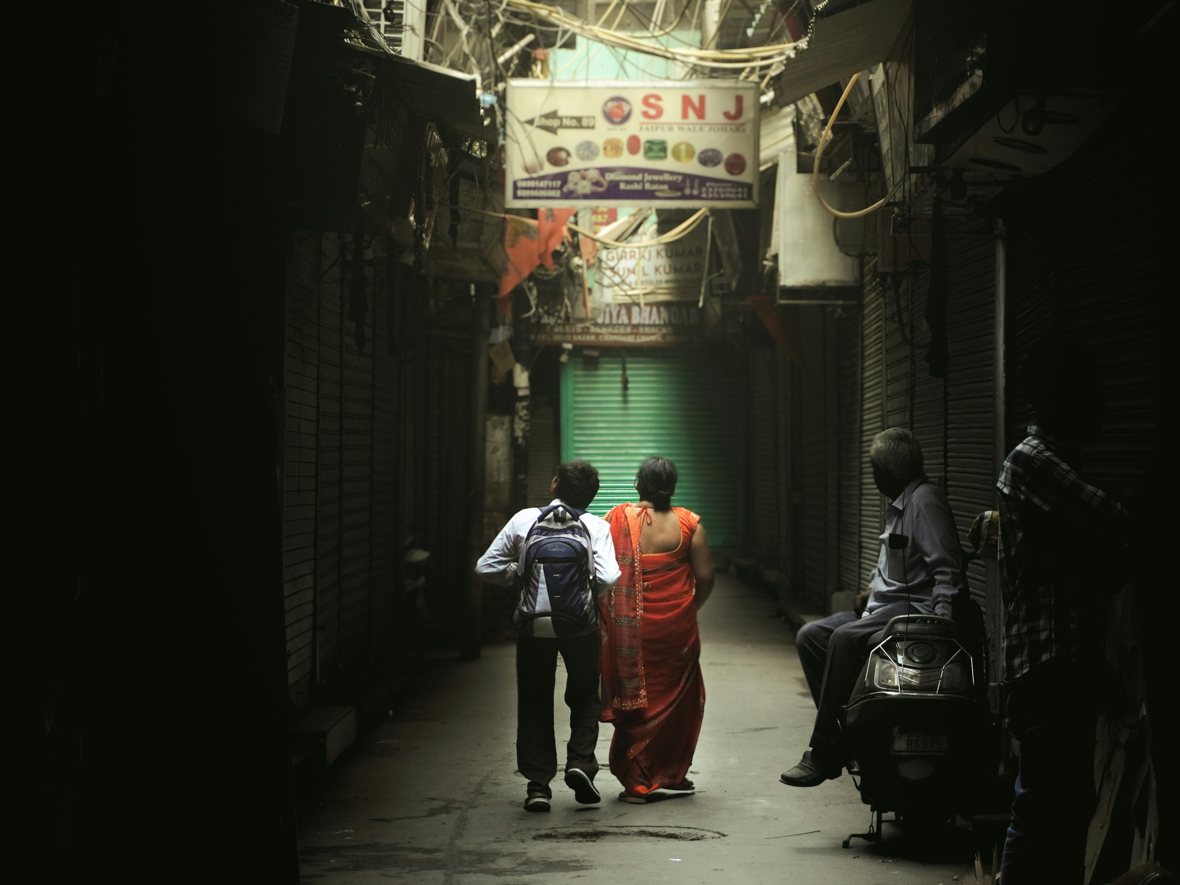 Red Sari in a Dim Alley: A Quiet Exit Through Shuttered Shops