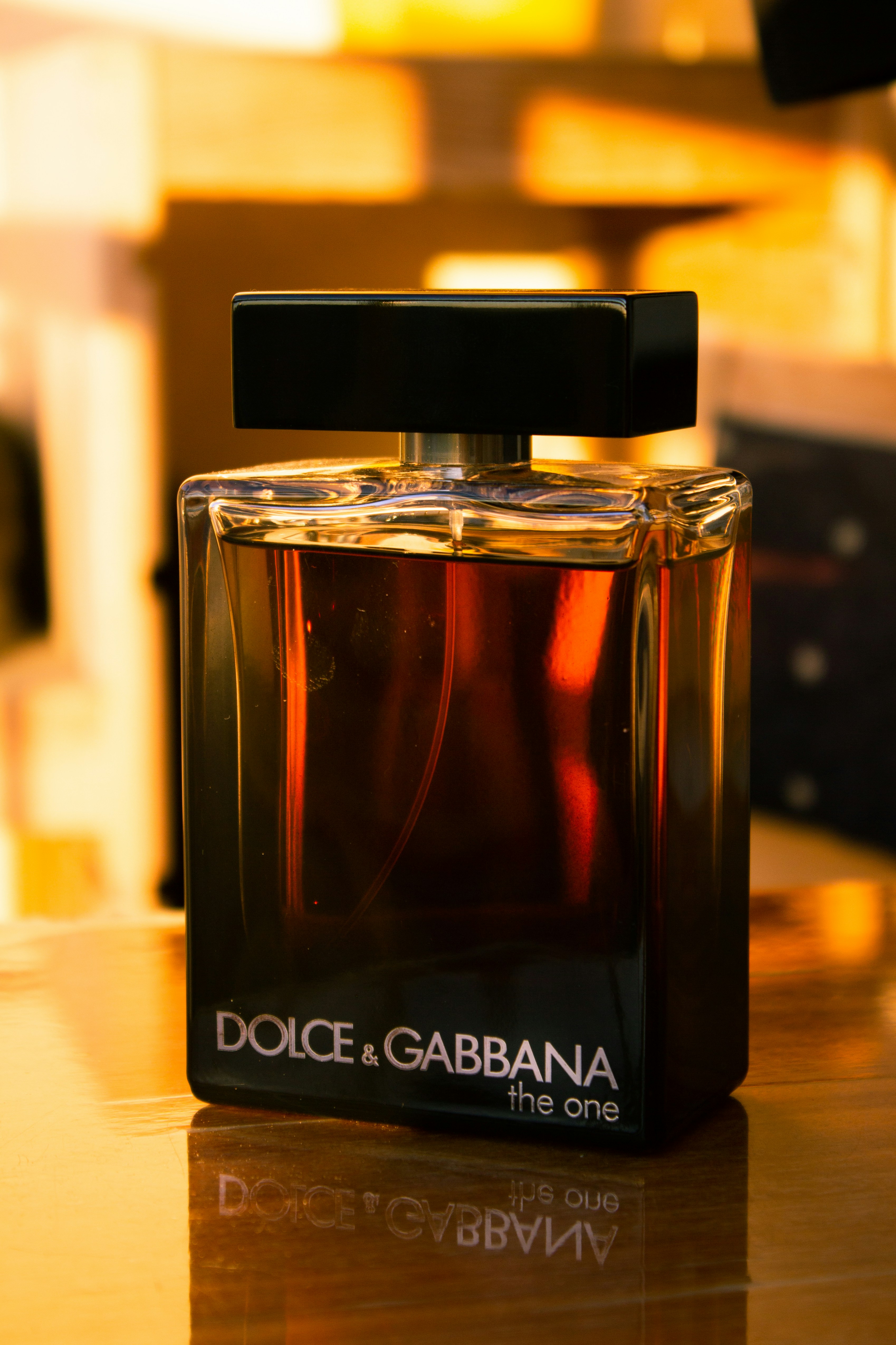 Amber Glass in Golden Quiet: Dolce & Gabbana The One on a sunlit surface