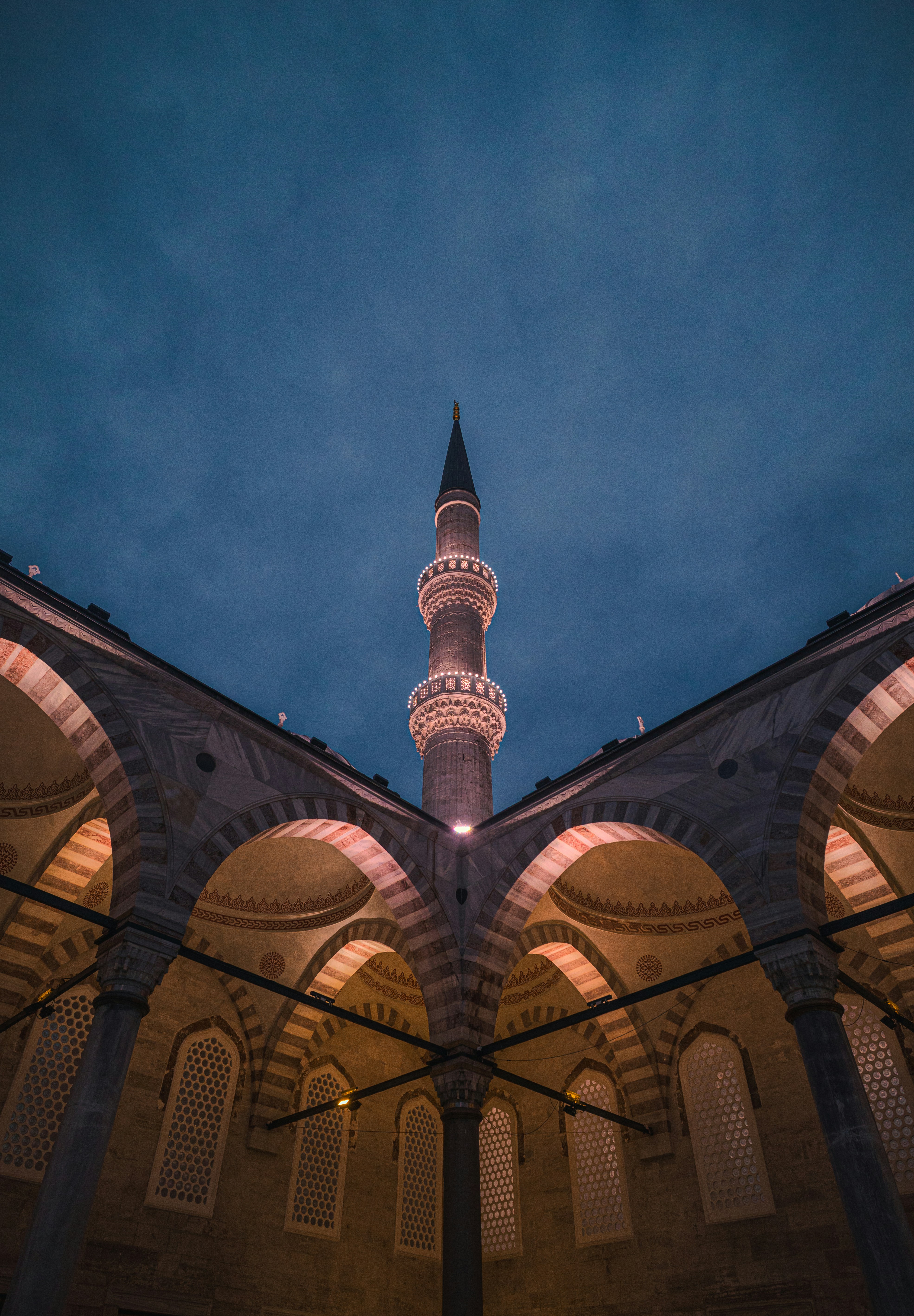 Crescent of Light: A Minaret Rises Over the Arched Courtyard at Dusk