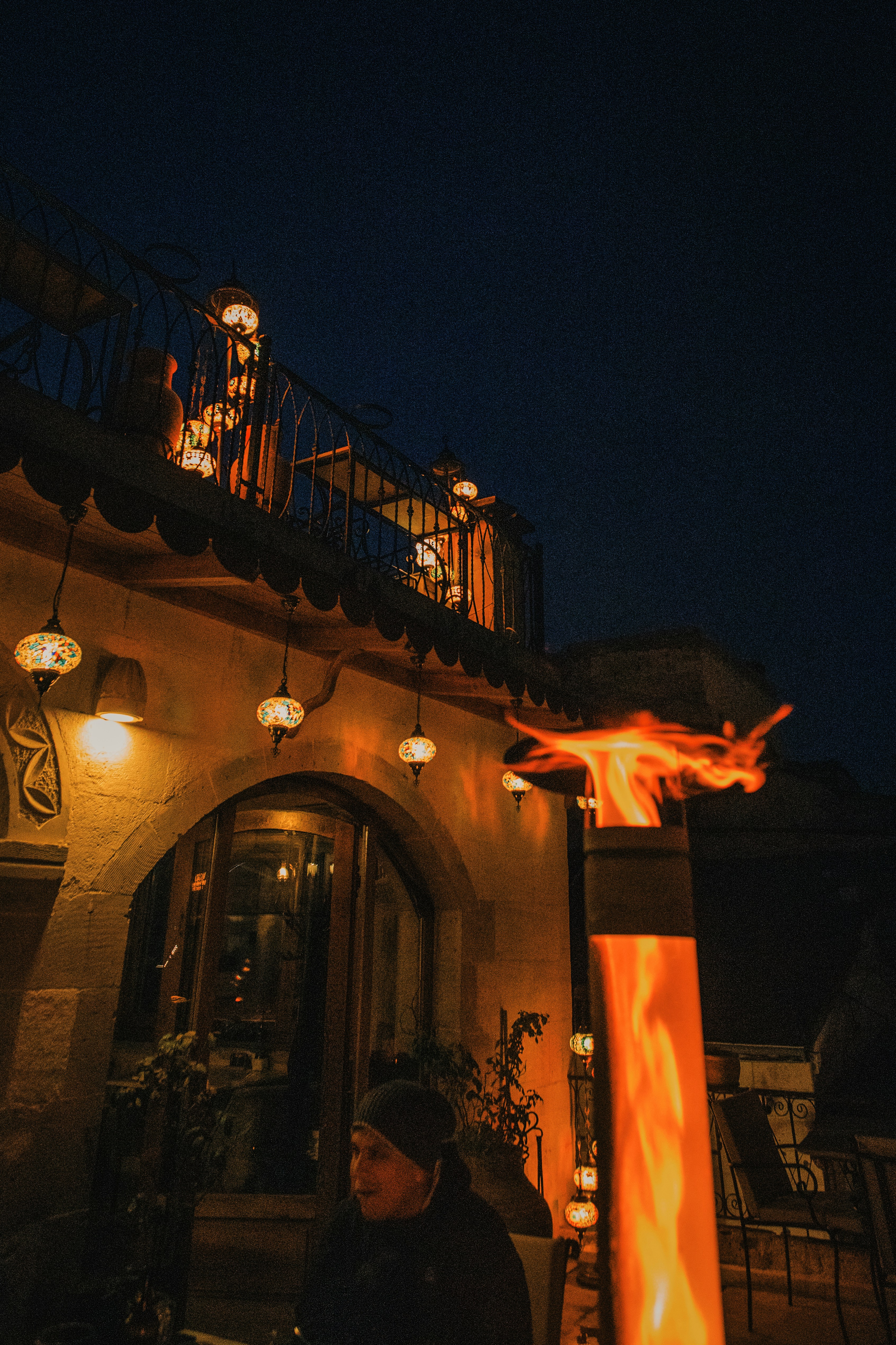 Embers on the Terrace: Lanterns, Stone Arch, and a Torch's Glow