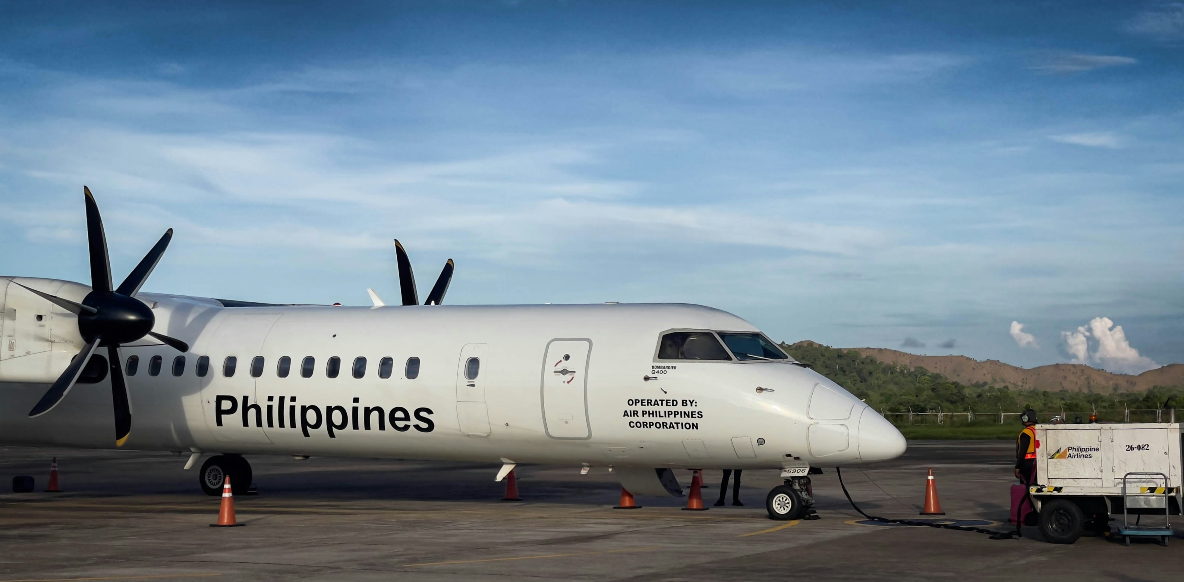 Ready on the Ramp: A Philippines turboprop at the edge of the tarmac under a clear sky