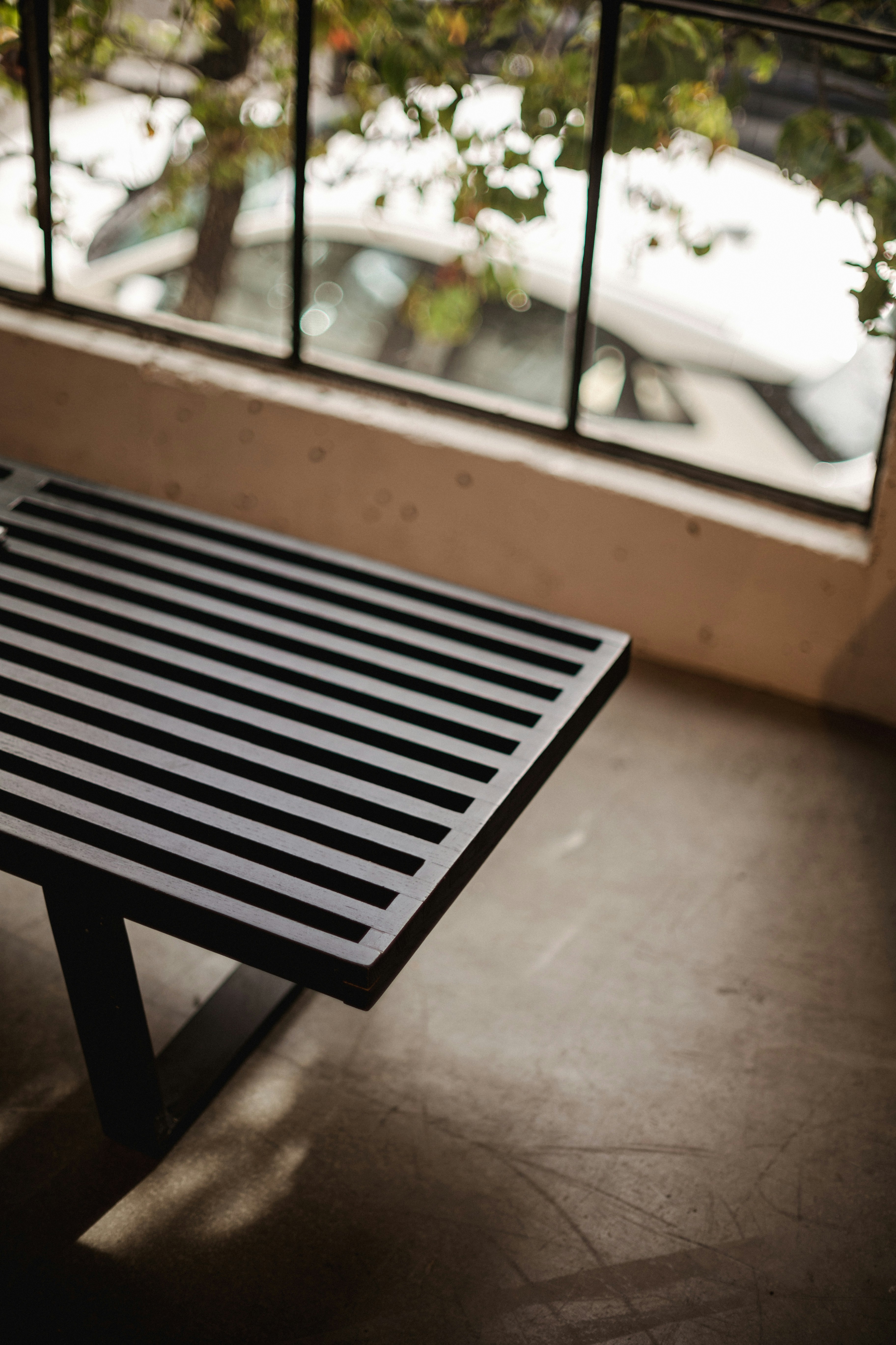 Slatted Table in Quiet Interior with Sunset-Faced Window