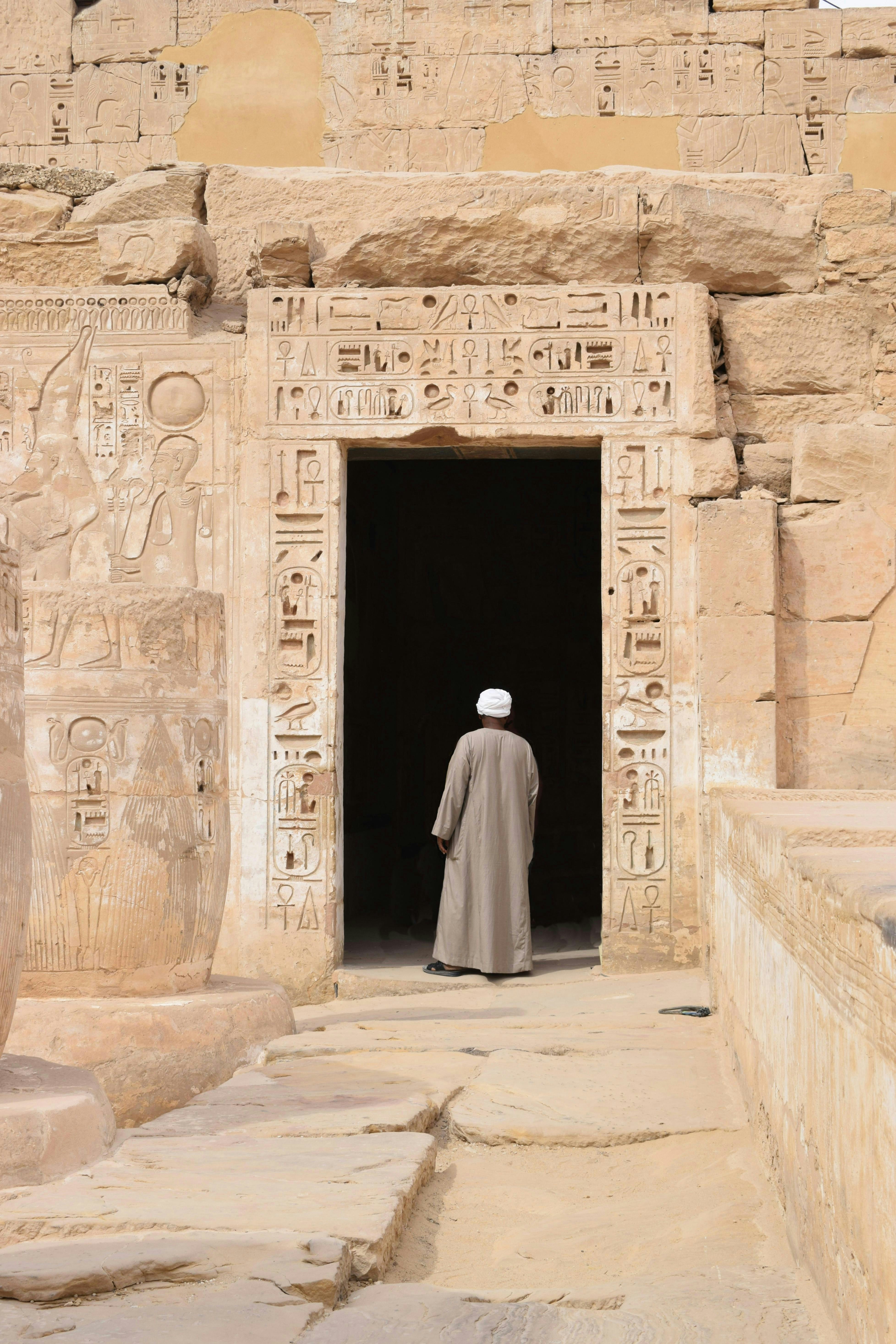 Un hombre con ropa tradicional entra en un templo del antiguo Egipto ...