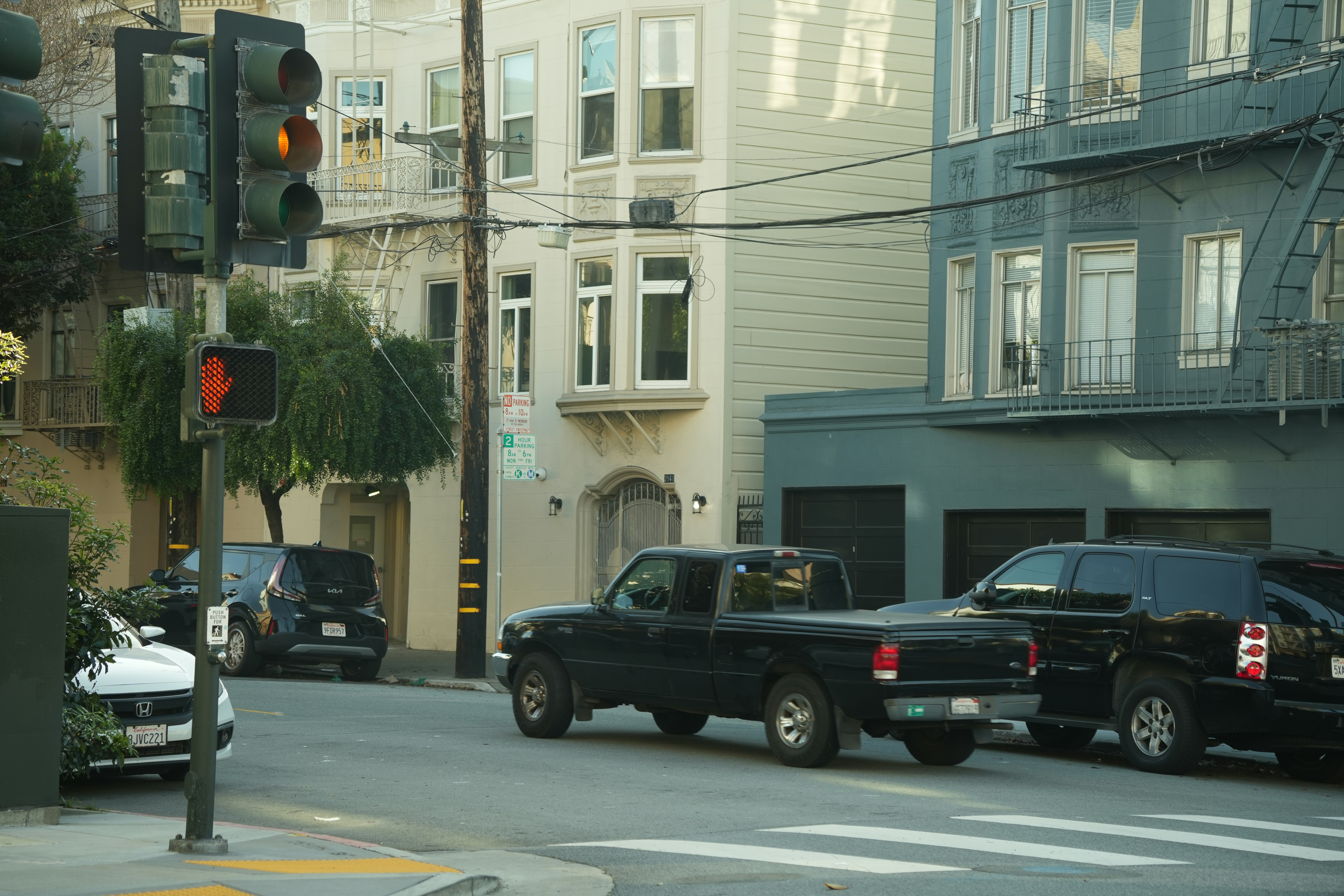 Red Signal at the Corner: A Quiet Street Scene with Trucks
