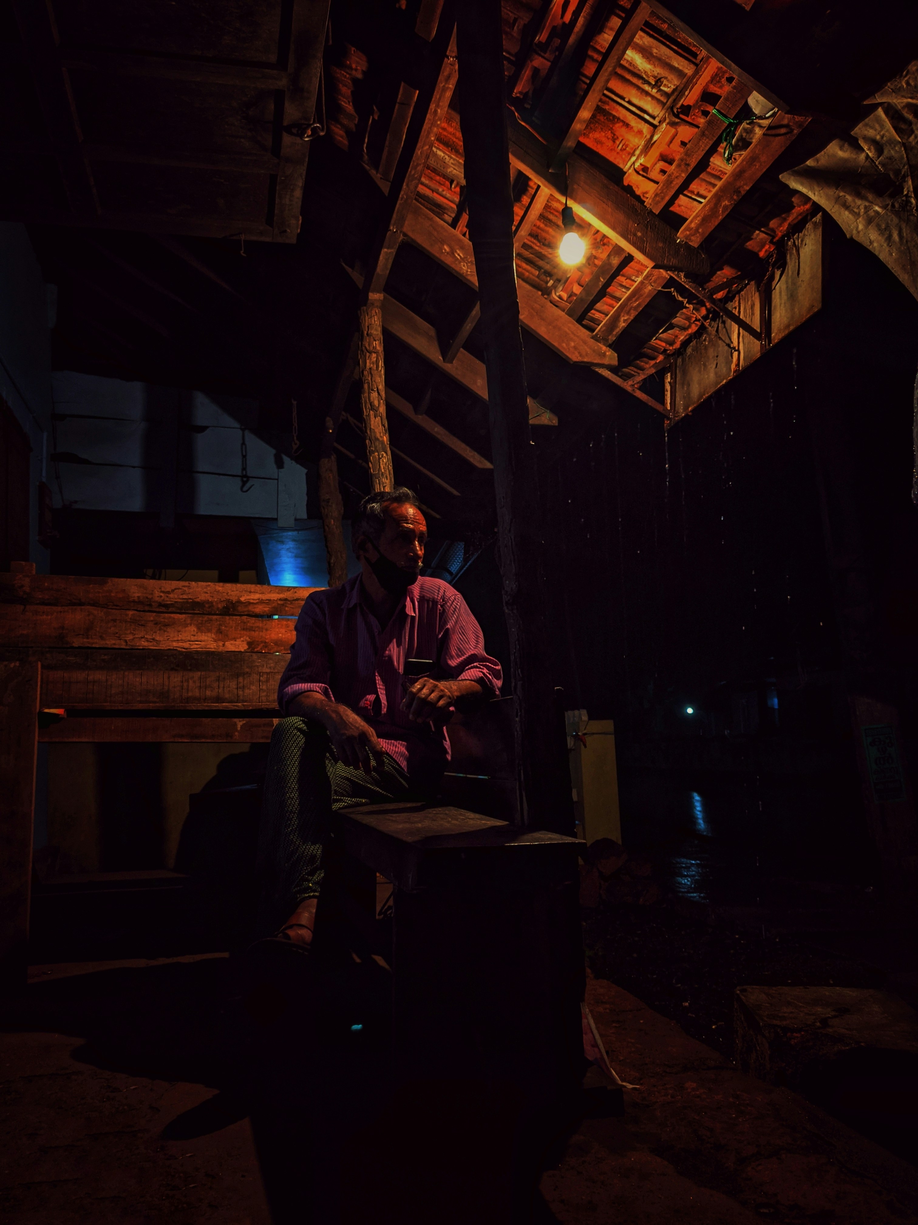 Low-Light Harbor: A Man in Shadowed Workshop