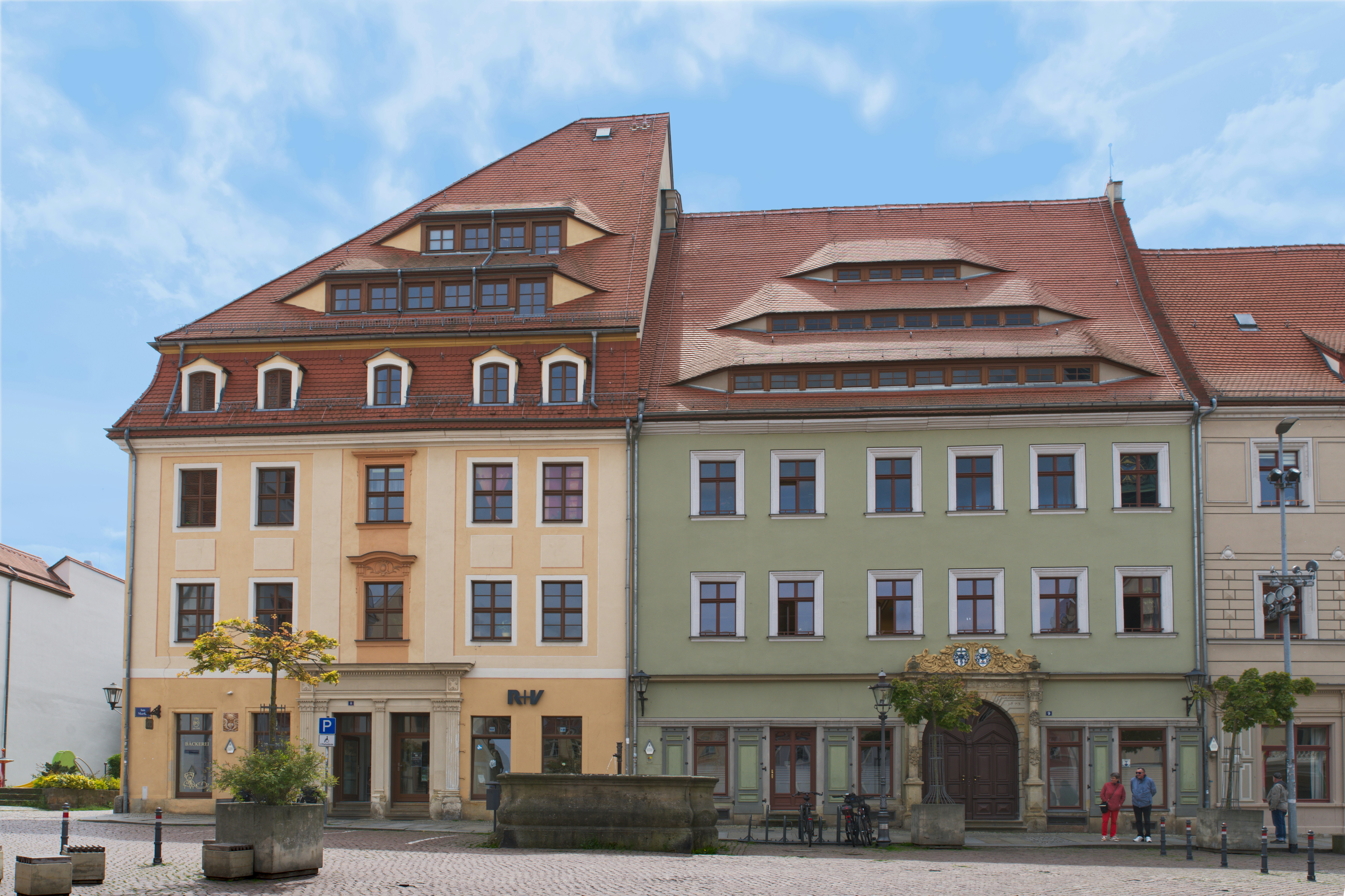 Big renovated buildings with dormer windows in the large roofs.