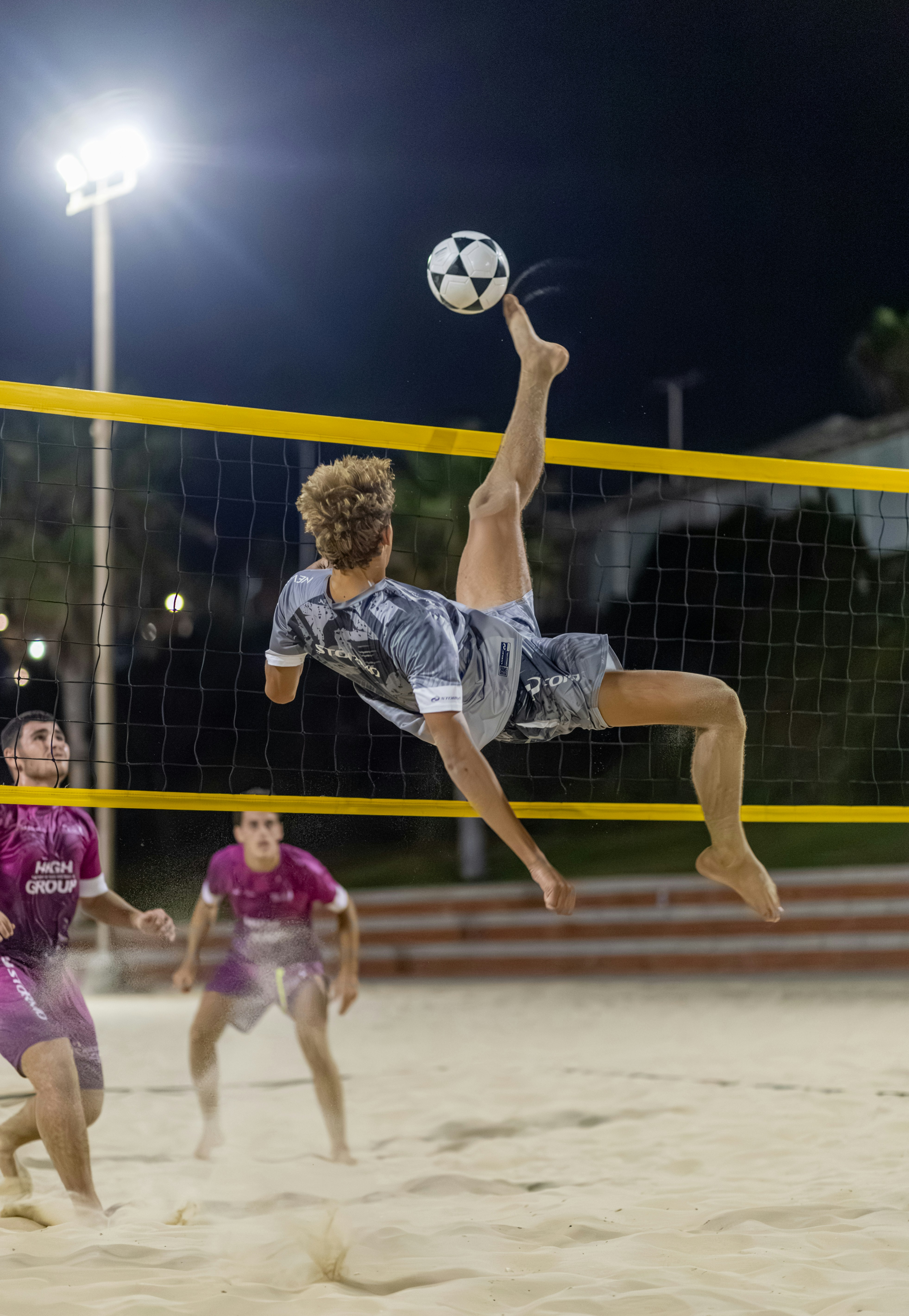 Aerial Spike: Night Beach Volleyball Defying Gravity