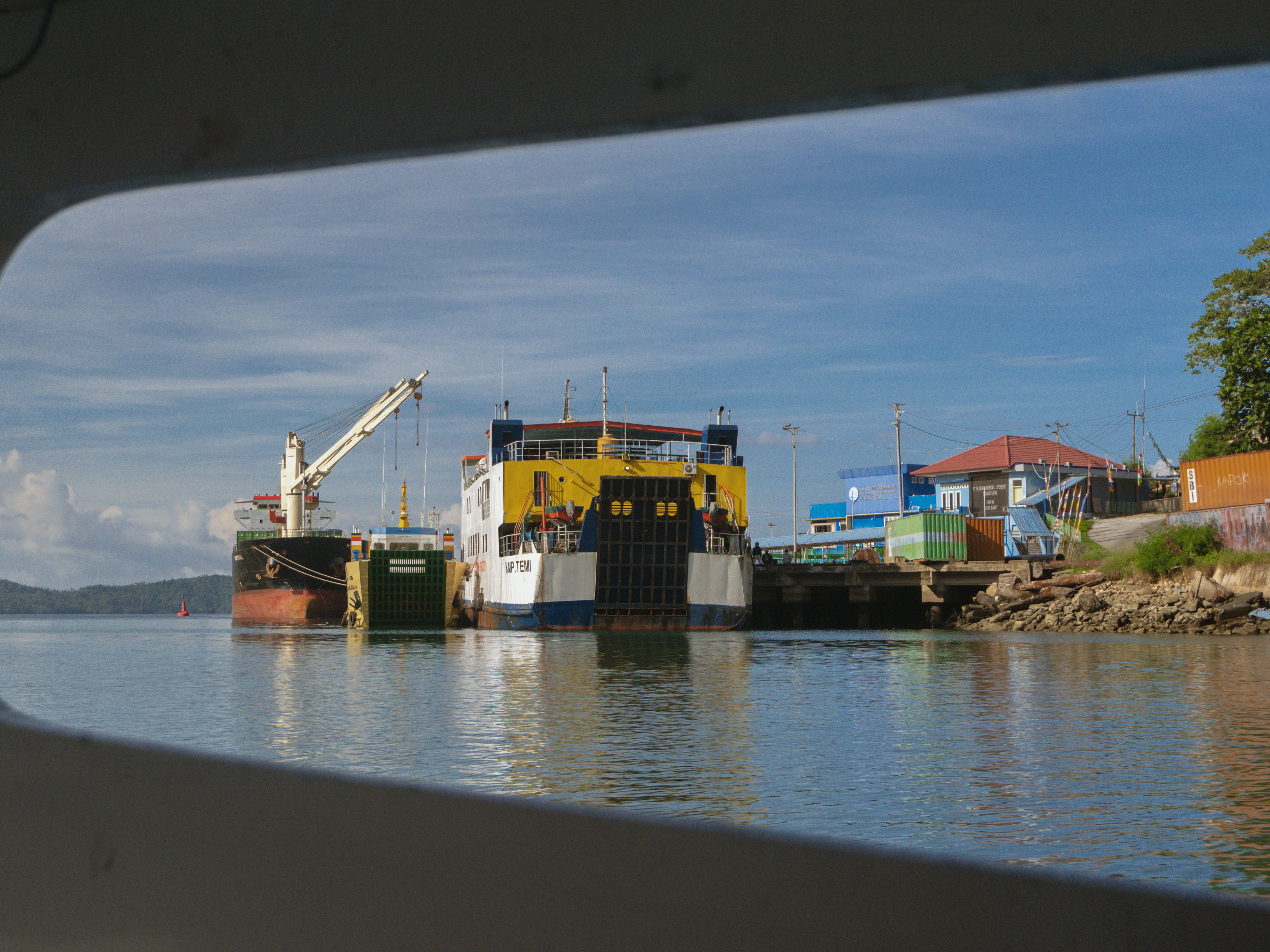 Ferry atracó en un puerto tropical con barcos de carga. foto – Imagen ...