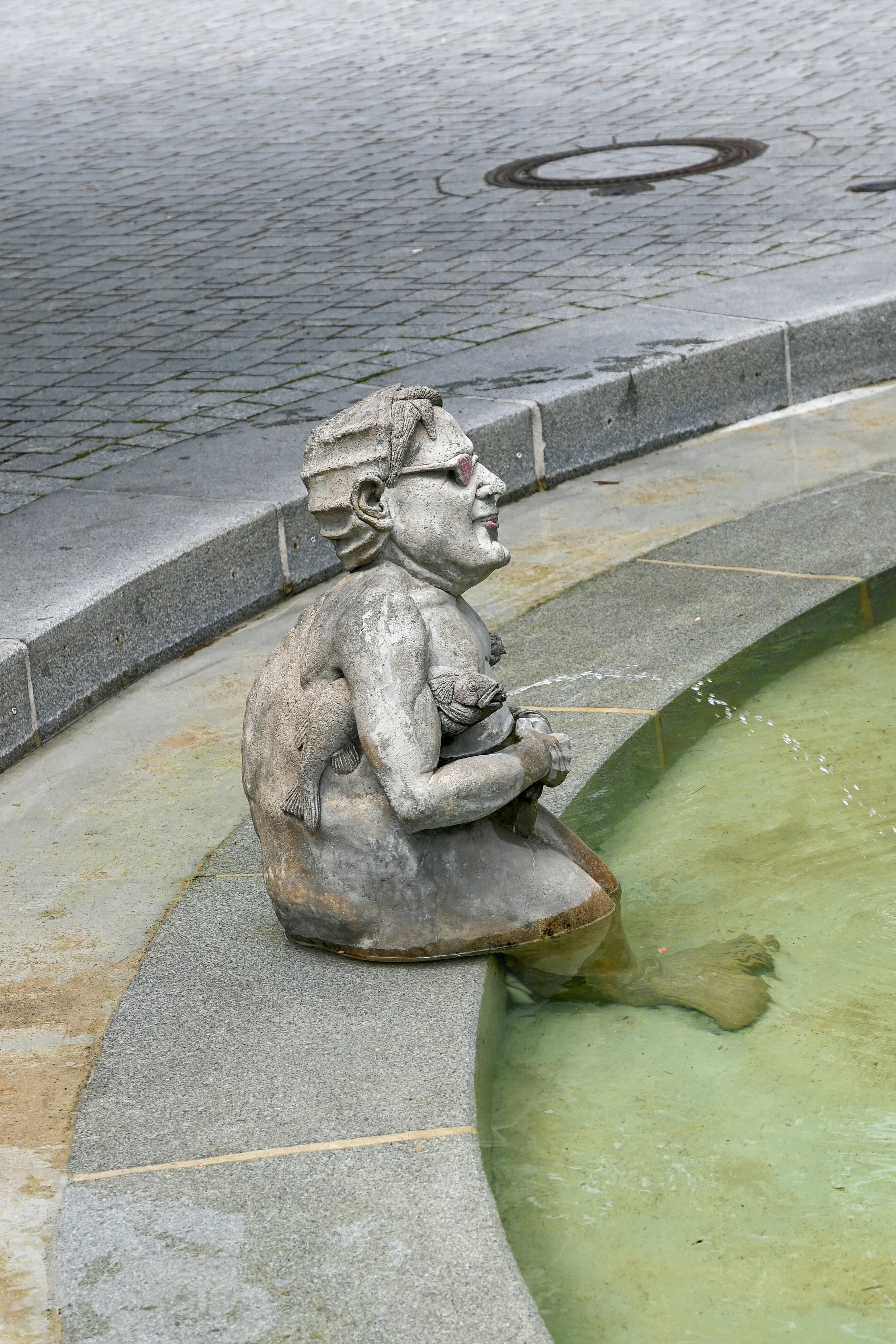 Watcher of the Circular Fountain: A Weathered Stone Figure