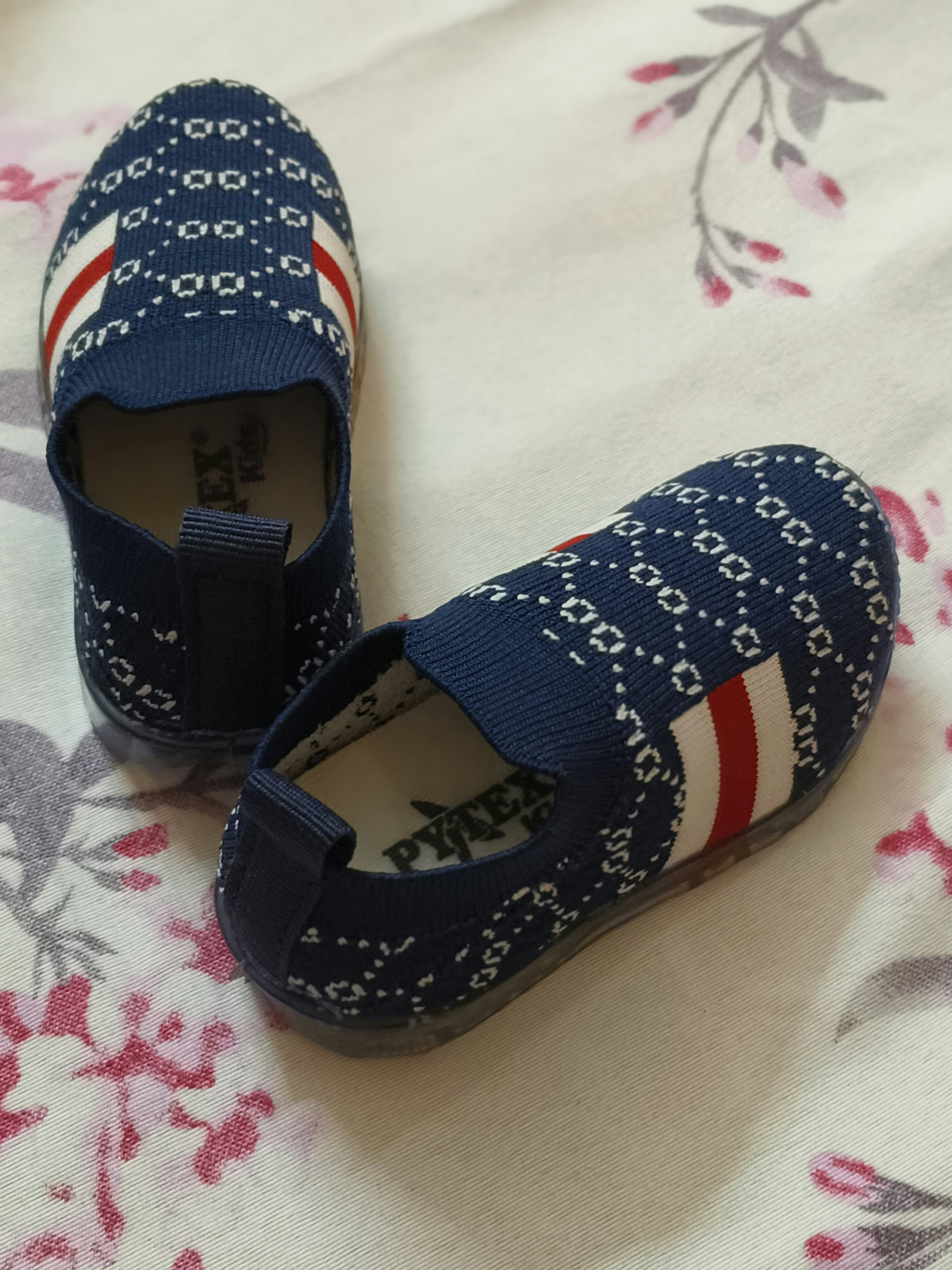 A pair of blue slip-on shoes with white pattern.