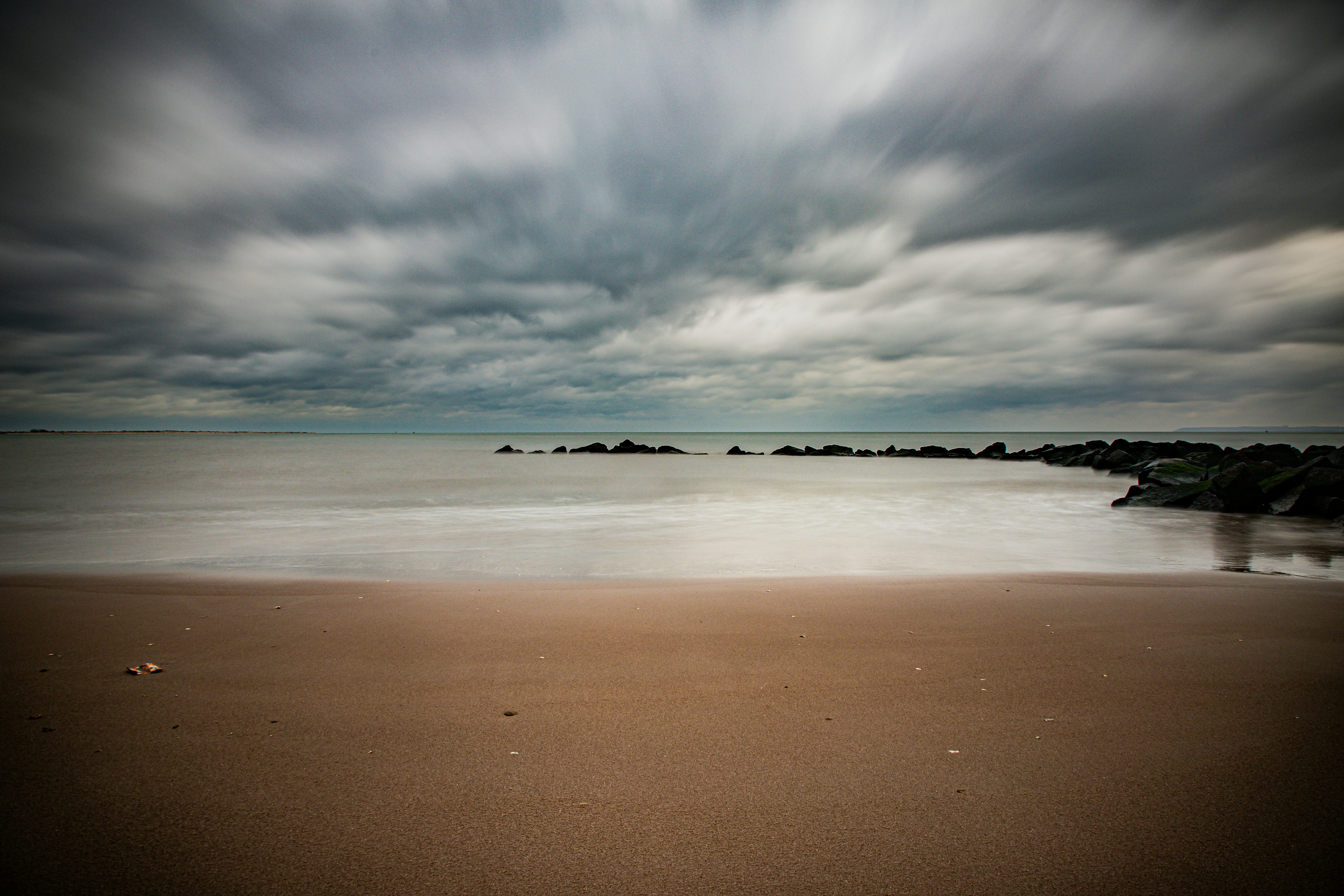 Horizon in Quiet Drift: A Cloud-Swept Beach Long Exposure