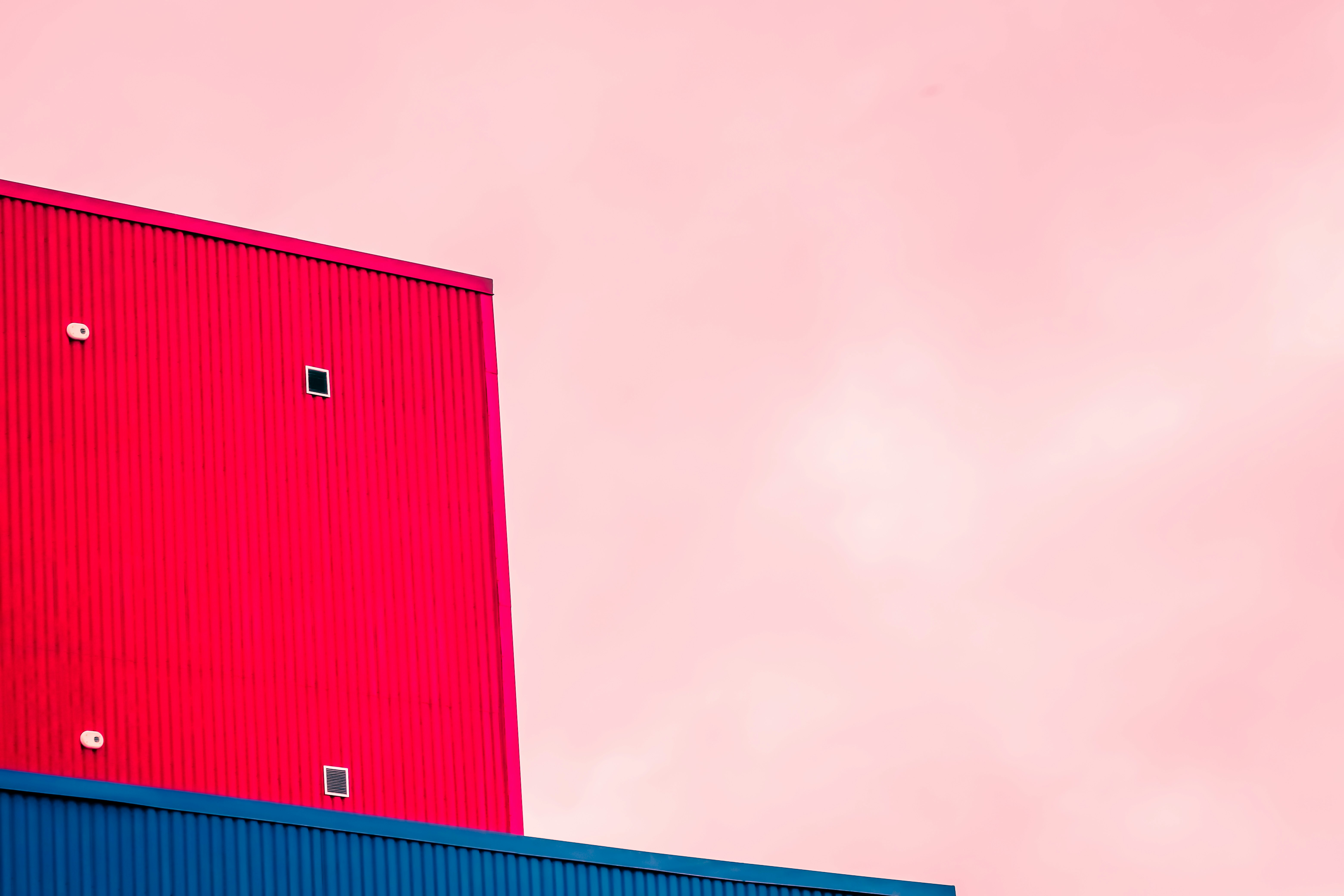 Crimson Facade Over Blue Band Beneath a Pastel Sky