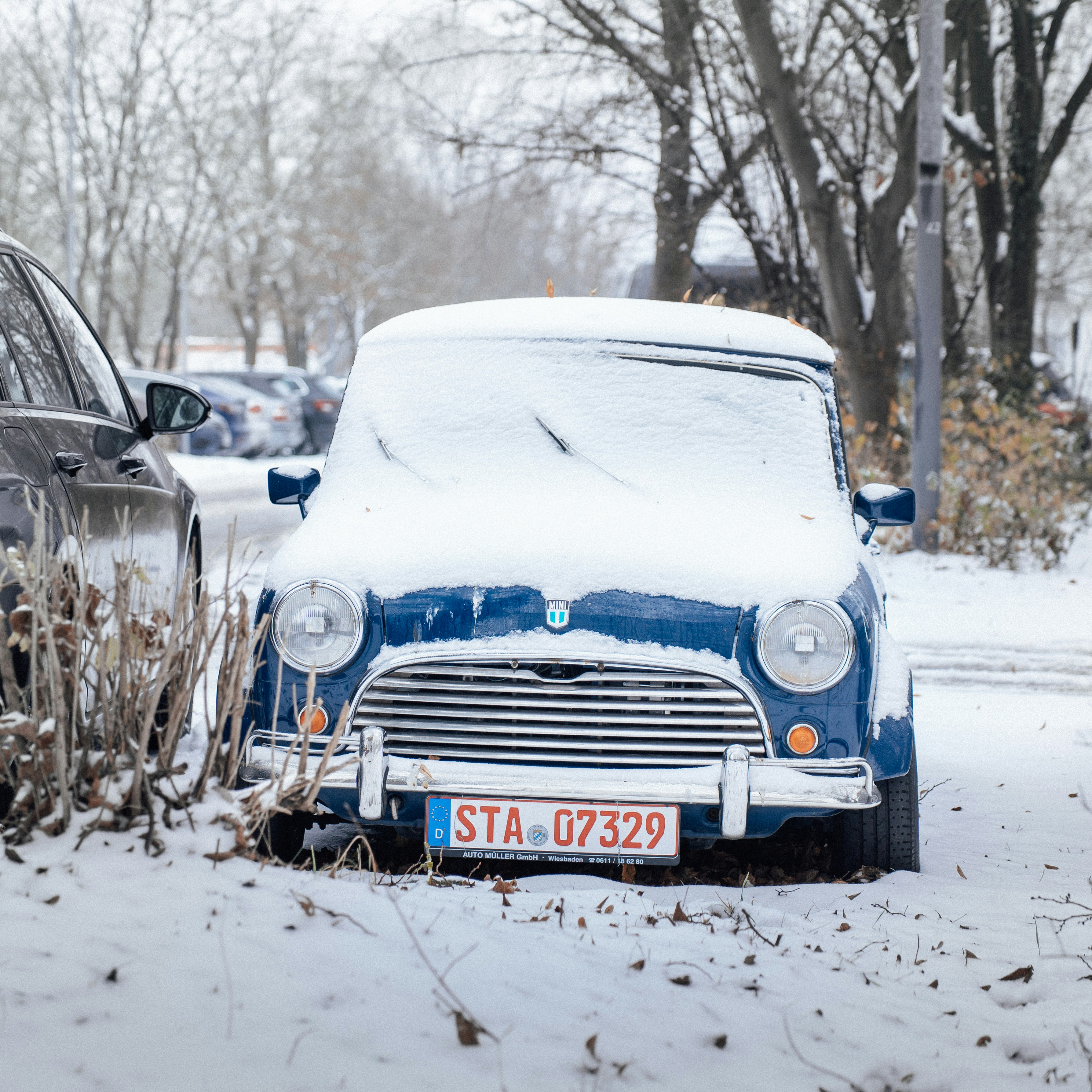 Snowbound Blue: A Vintage Car Graces a Quiet Parking Lot