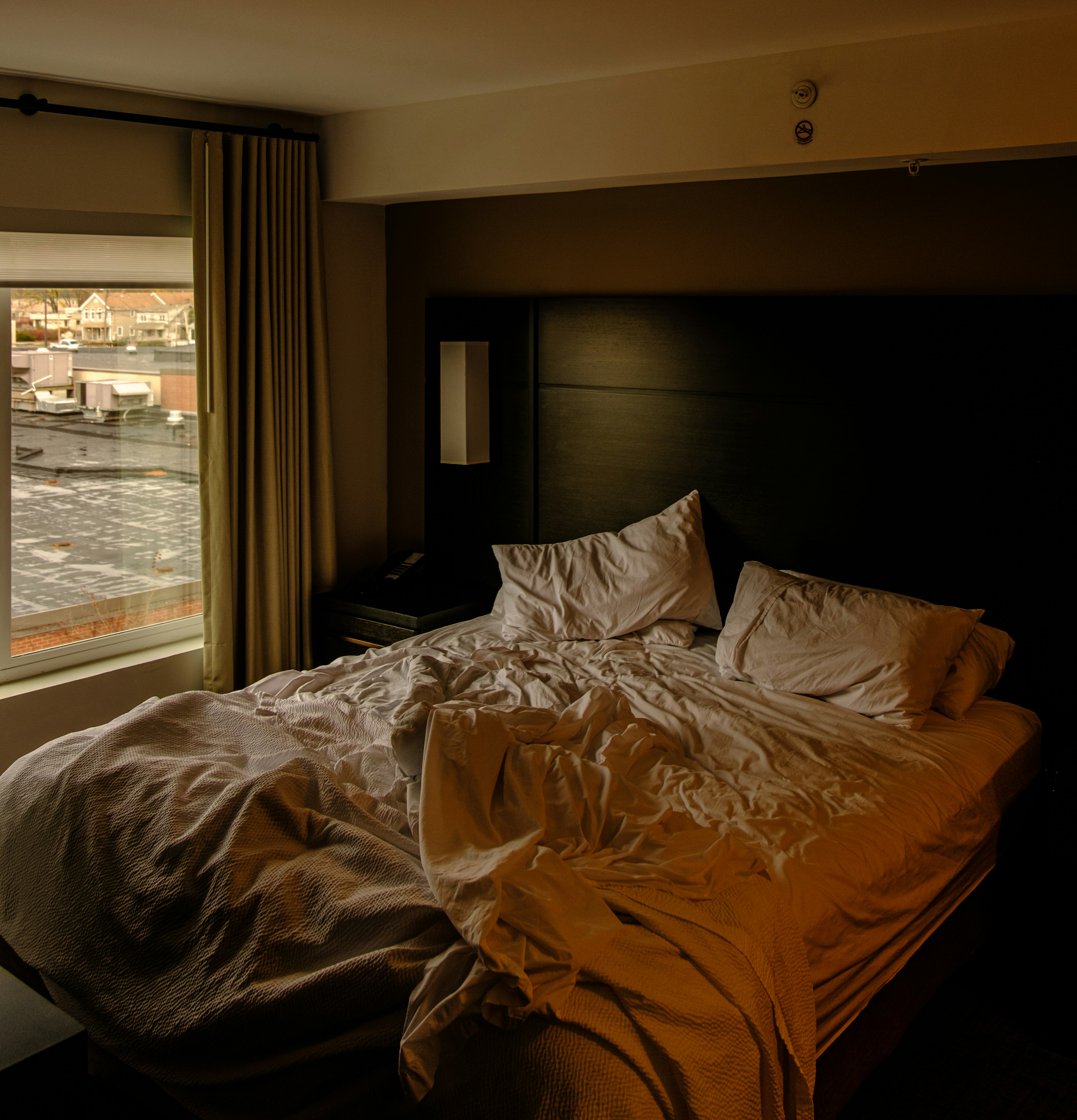 Harbor Glow Over an Unmade Hotel Bed