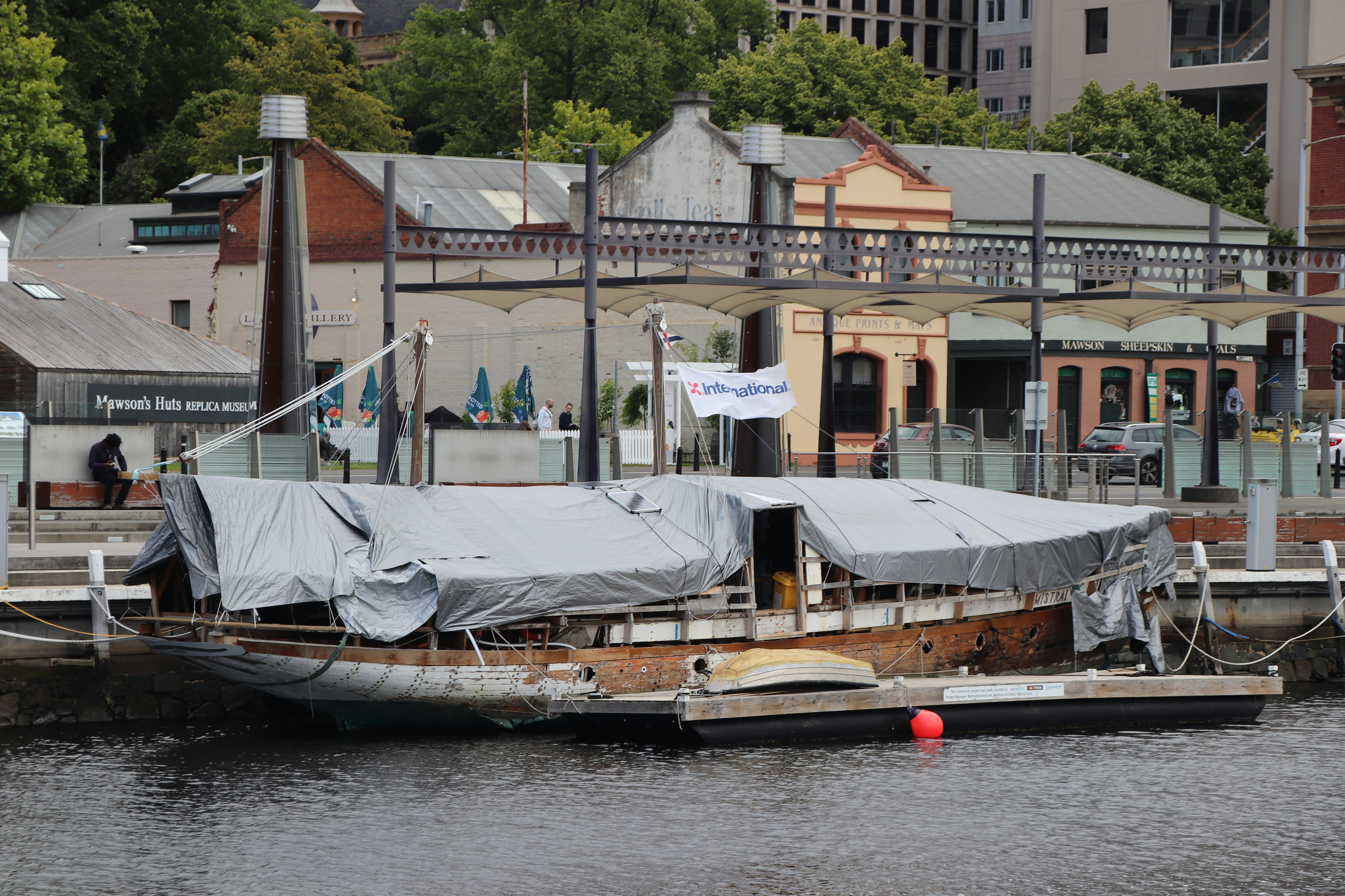 Harbor Boat in Shelter: a riverside scene with a covered craft tied to a dock