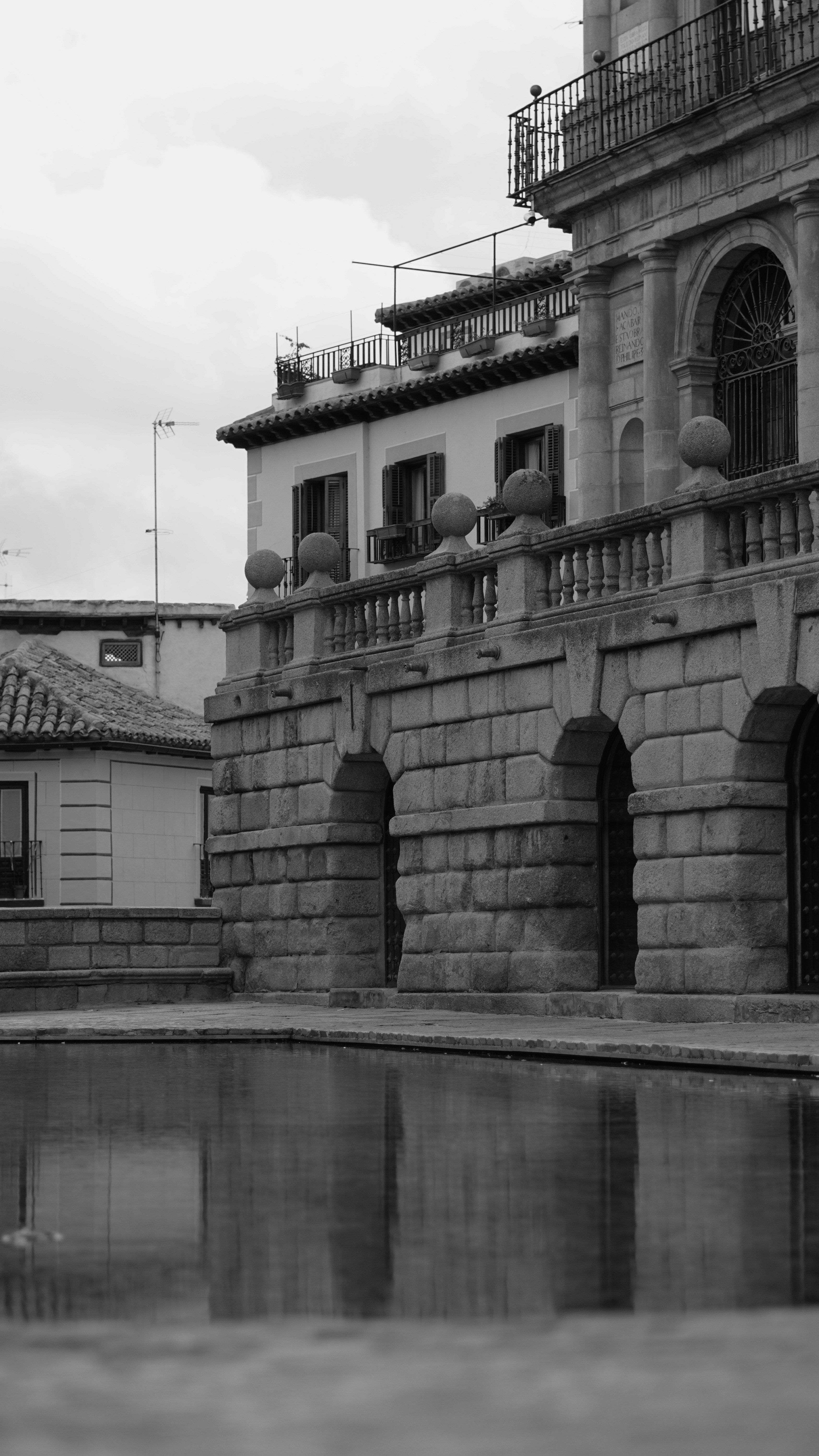 Stone Arcades by the Water: A Monochrome Facade