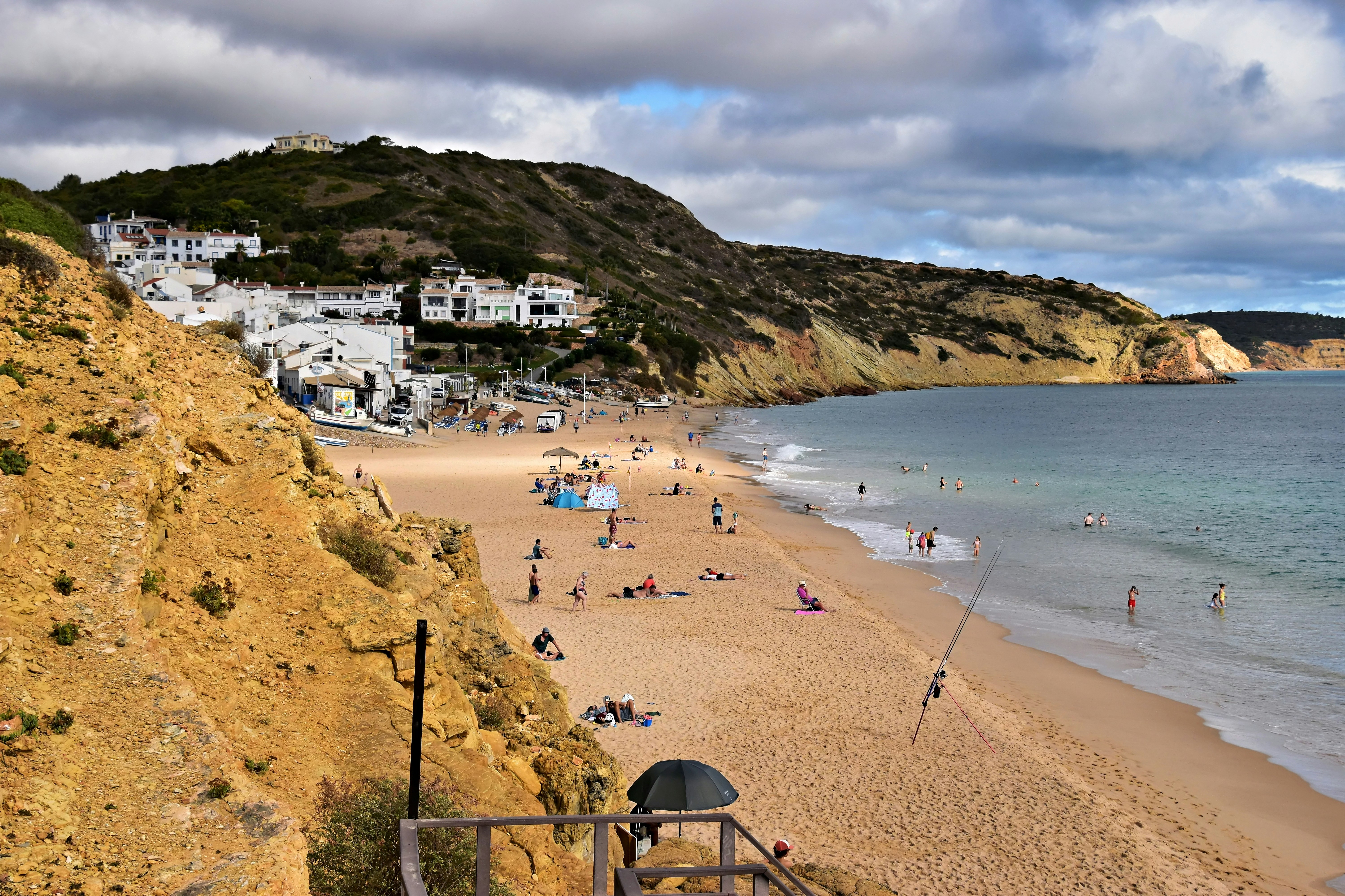 Sunlit Cove: Whitewashed Village Amid Golden Cliffs
