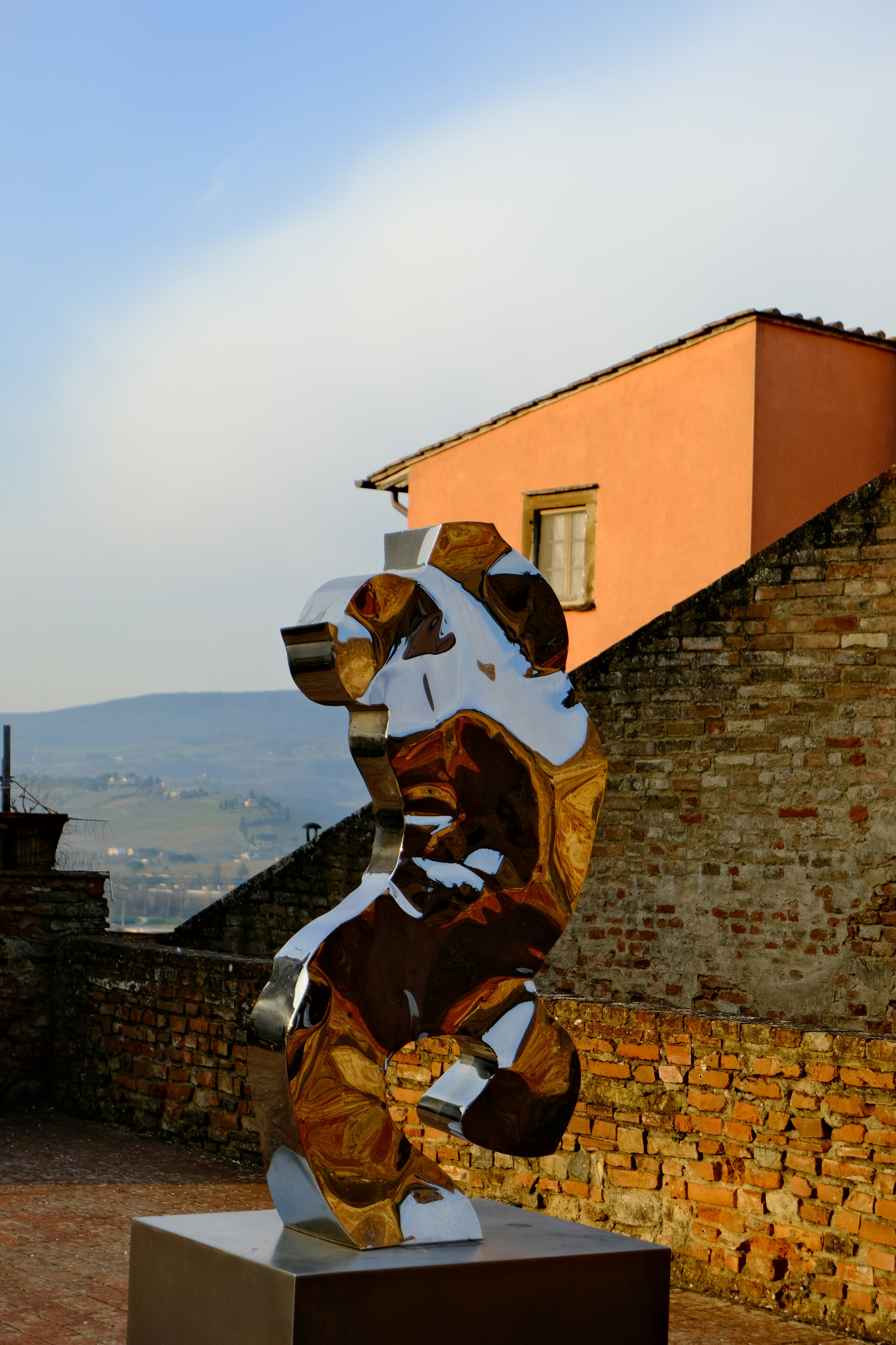 Mirror of Hills: A Polished Figure Against a Tuscan Brick