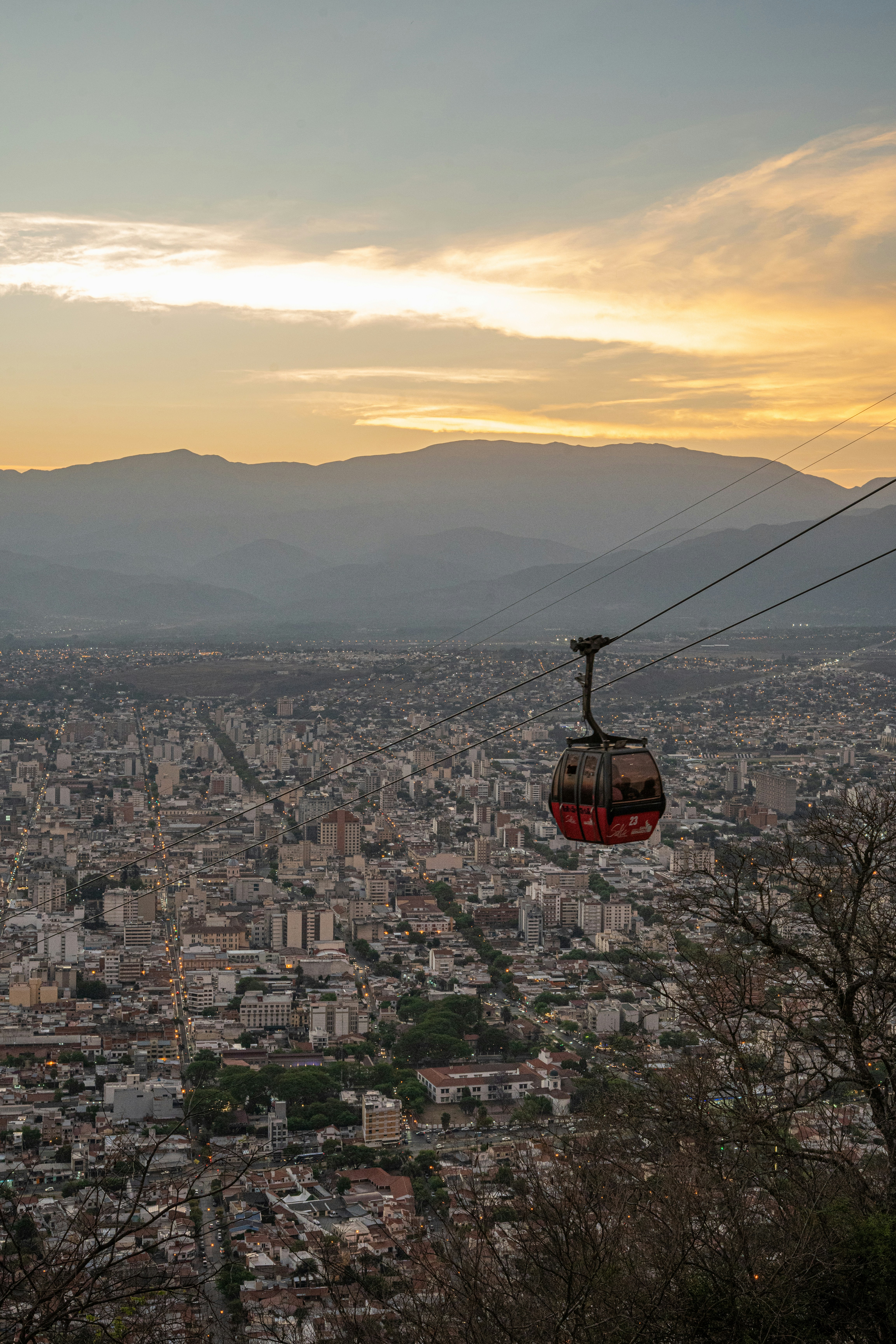 Crimson Gondola Over a Dusk-Softened City