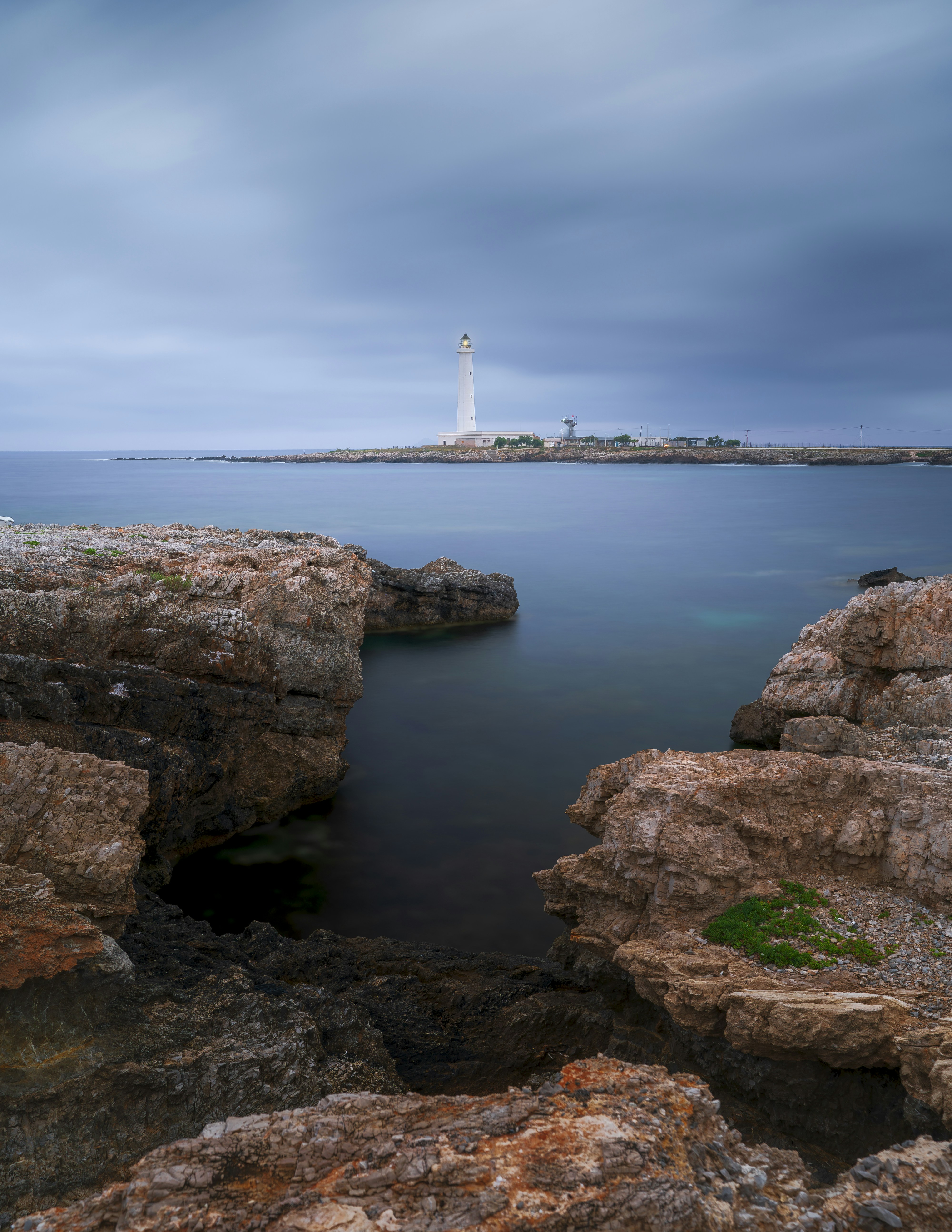 Beacon on the Quiet Horizon: Lighthouse Framing the Rugged Coast
