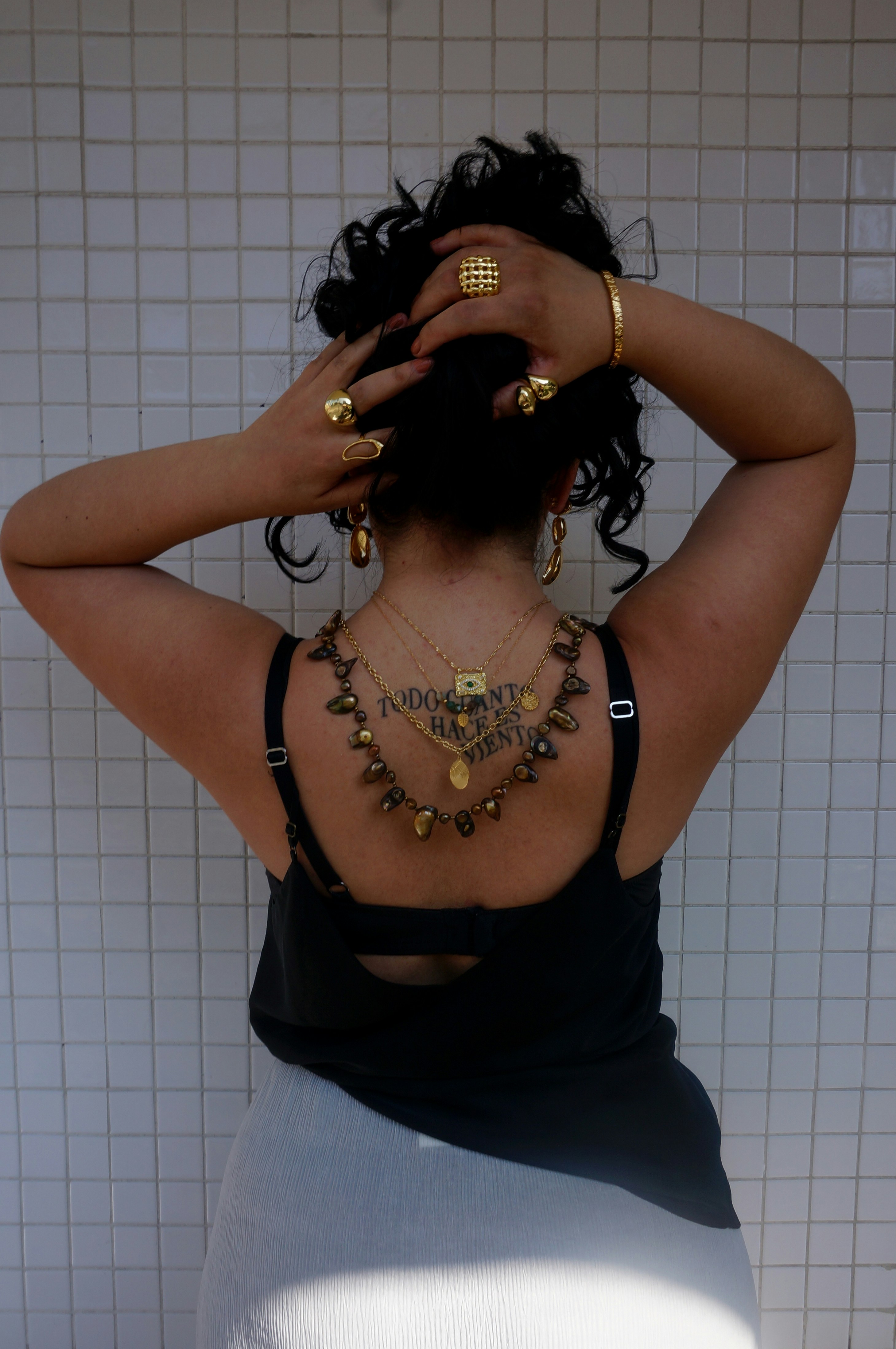 Gold Cascade on the Back: Jewelry Portrait Against a Tile Backdrop