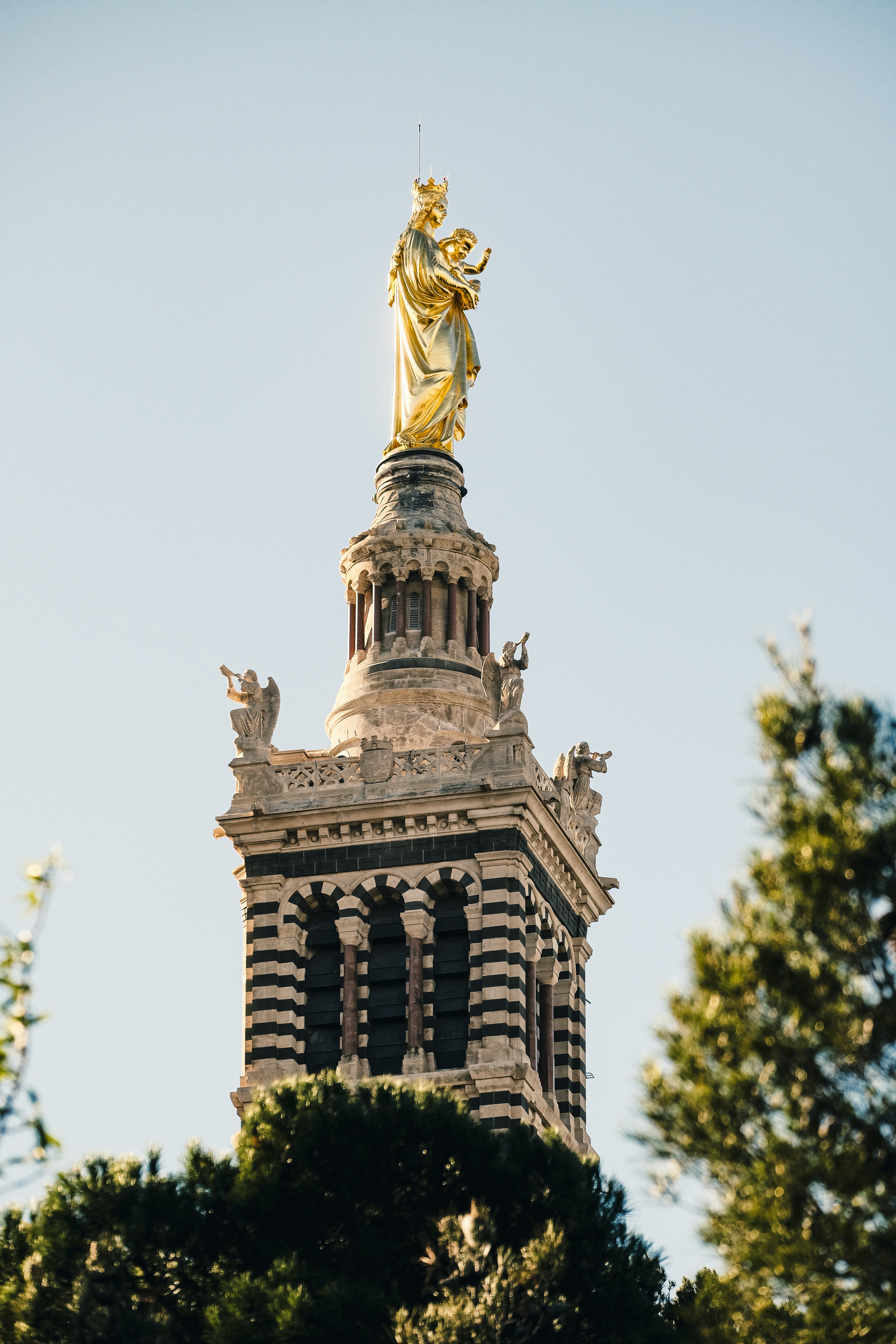 Gilded Sentinel at the Top of a Striped Tower