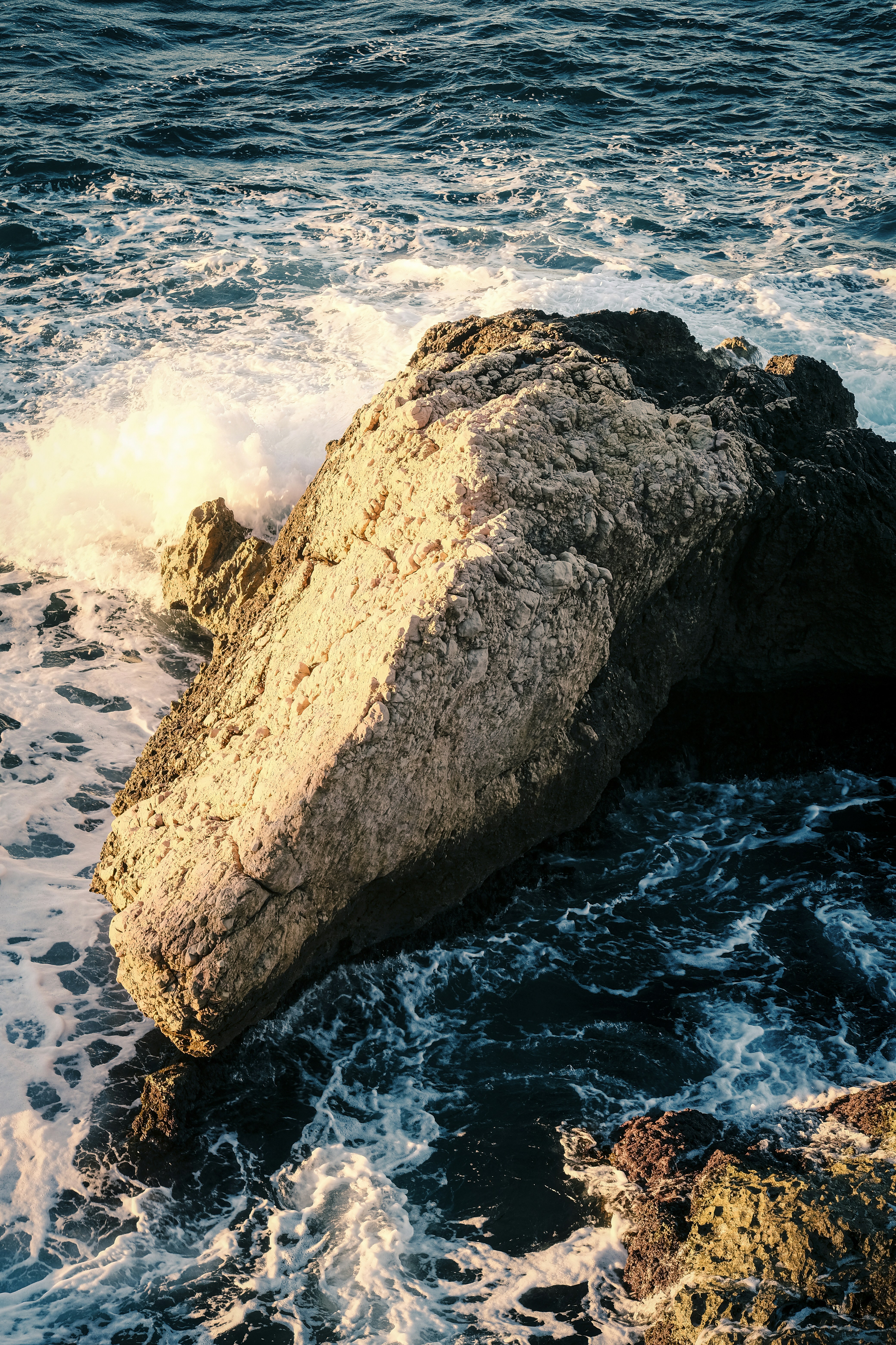 Sunlit Monolith Braving the Atlantic Swell