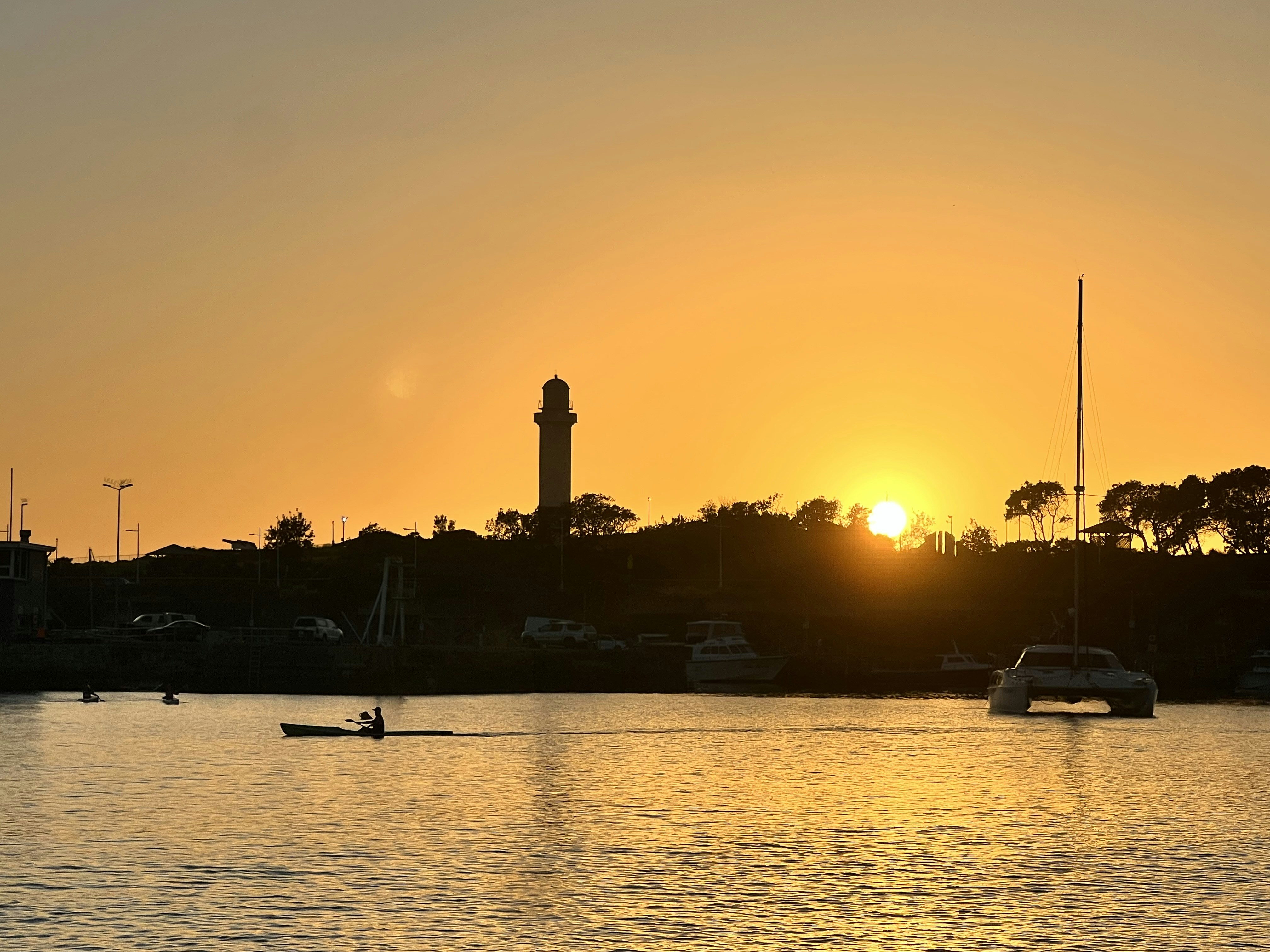 Golden Harbor: Sunset Silhouette by the Lighthouse