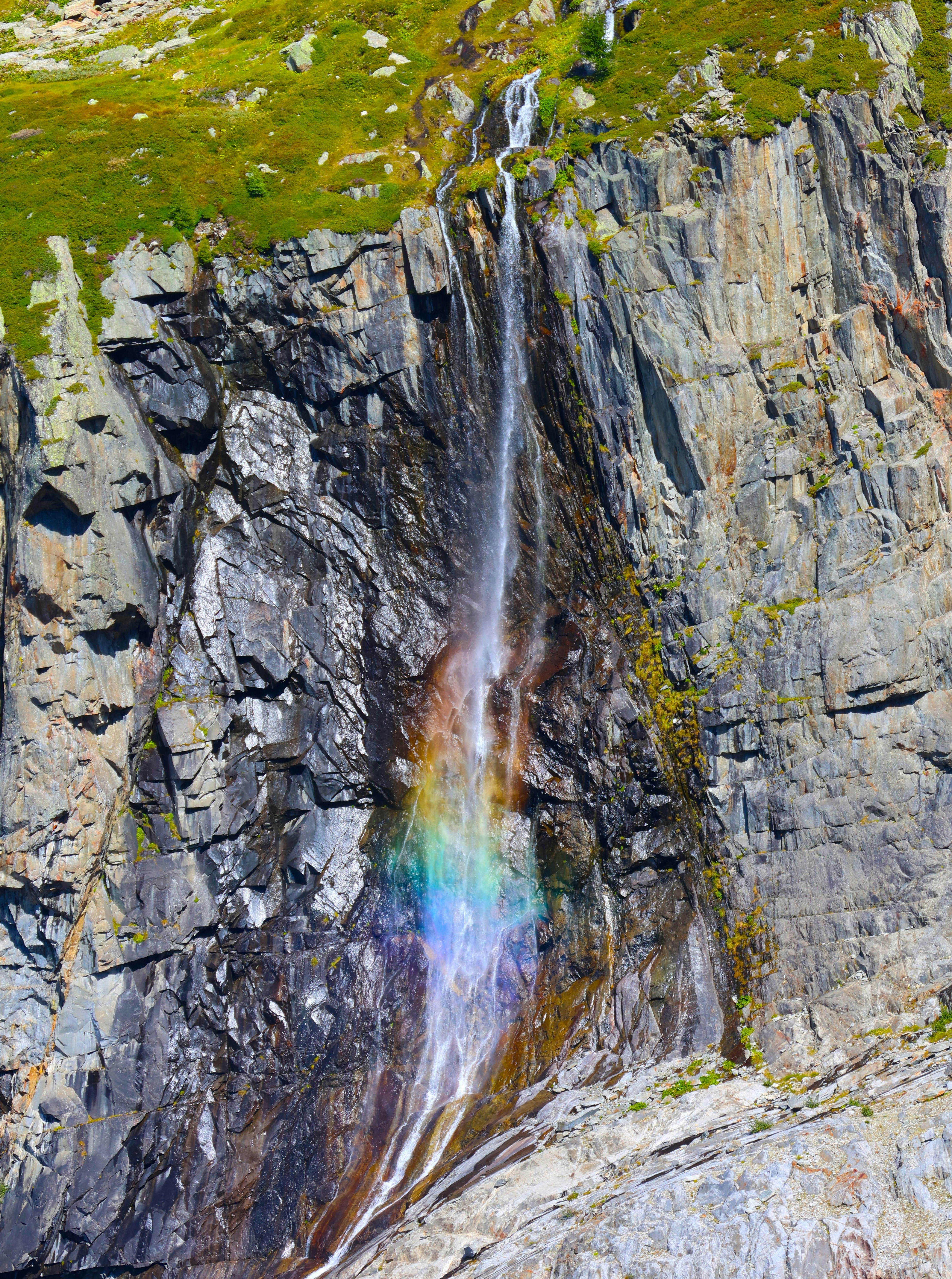 Rainbow Ribbon Cascading Over a Granite Cliff