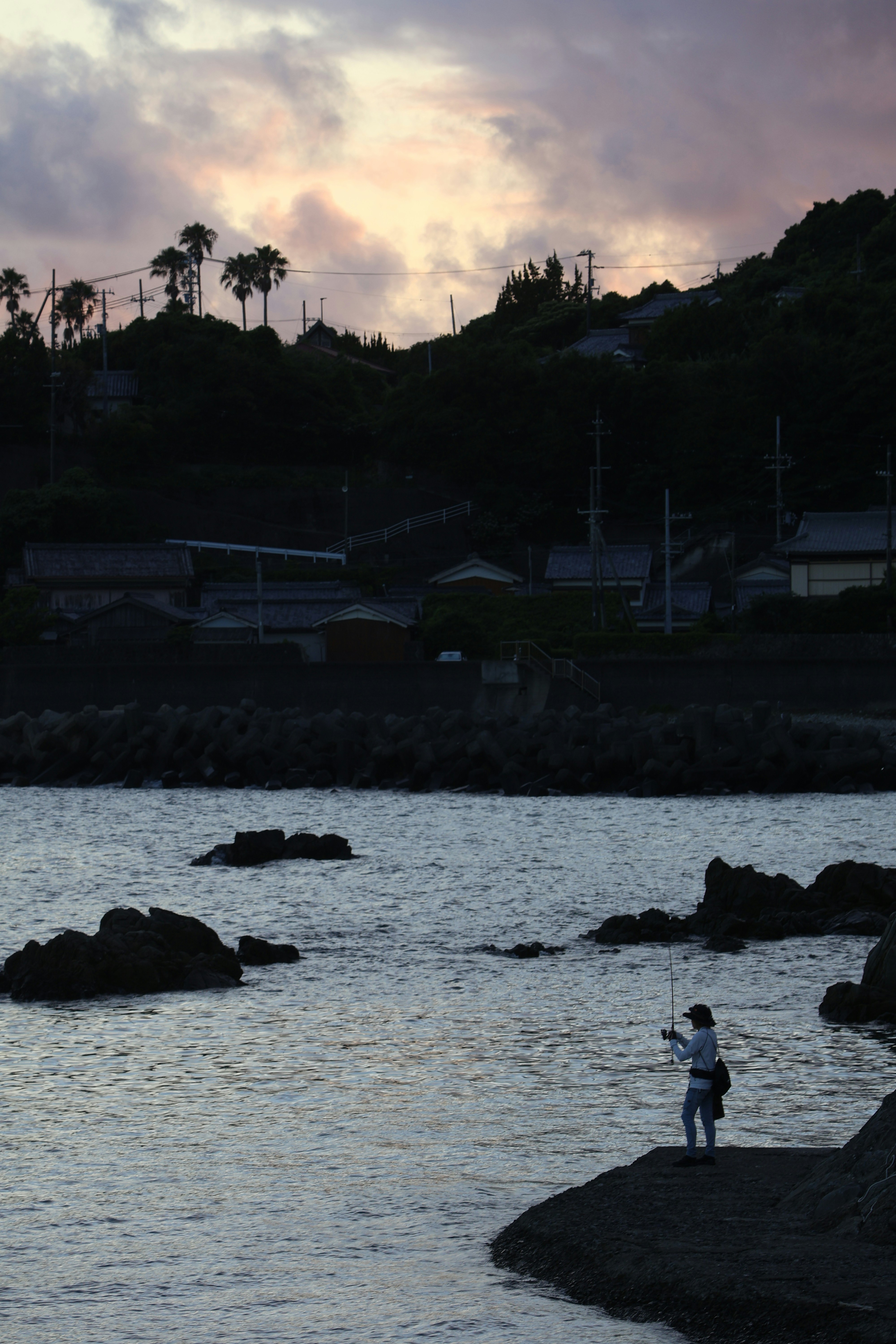 Dusk at the Cove: A lone figure on the rocky jetty