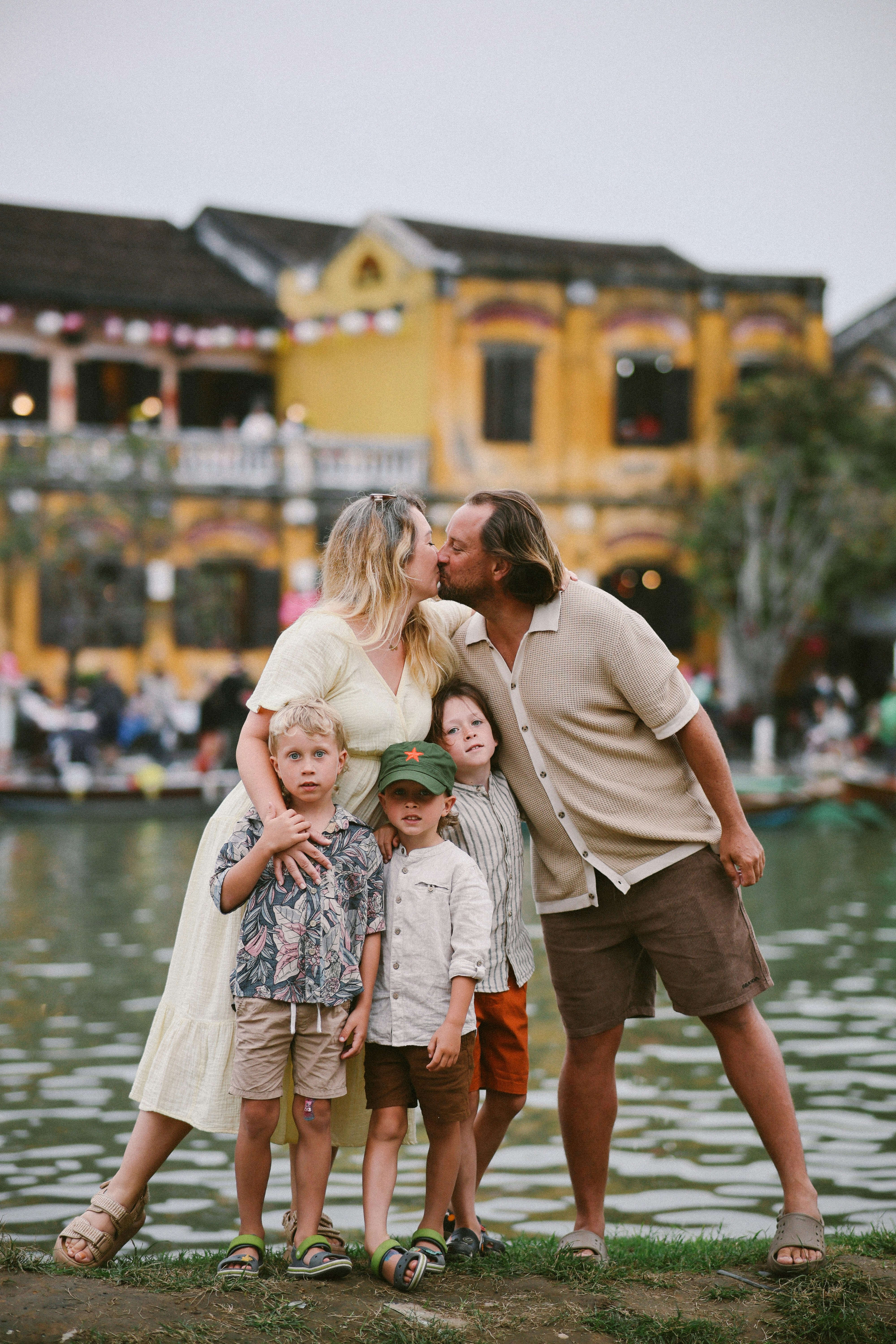 Kissing Moment by the Canal: Family Portrait in a Sunlit Square