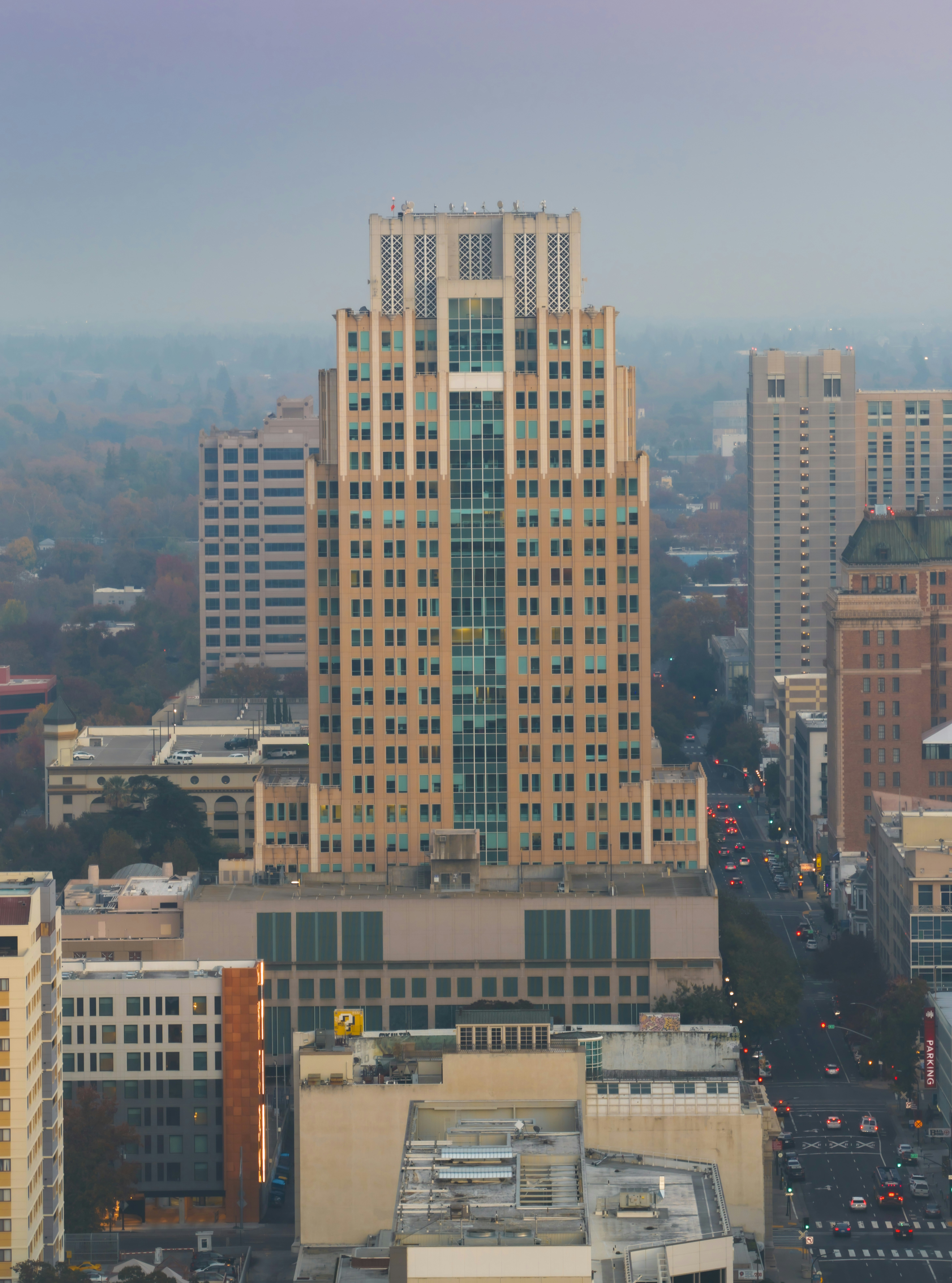The Central Sentinel: A Tall Beige Tower Anchoring a Lined Downtown