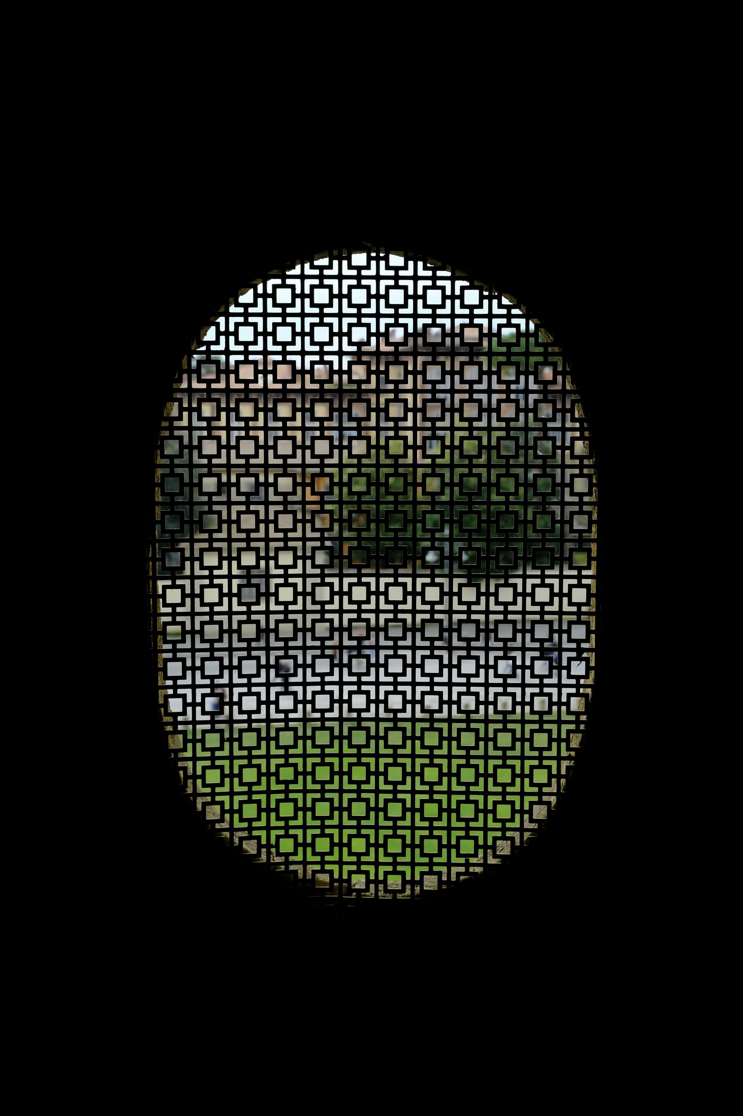Lattice Window: A Quiet Street Framed by a Circular Veil