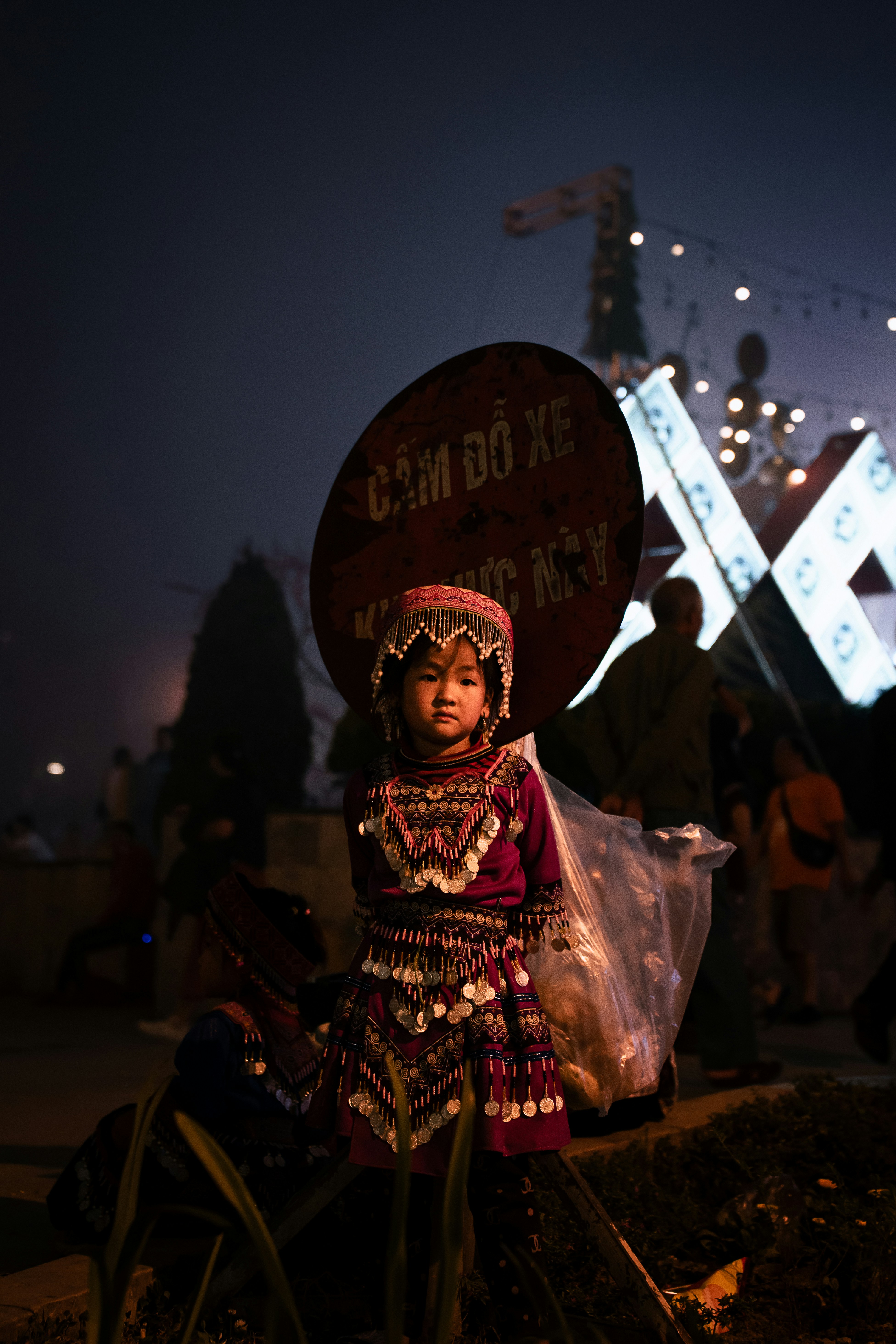 Young dancer in traditional attire under festival lights