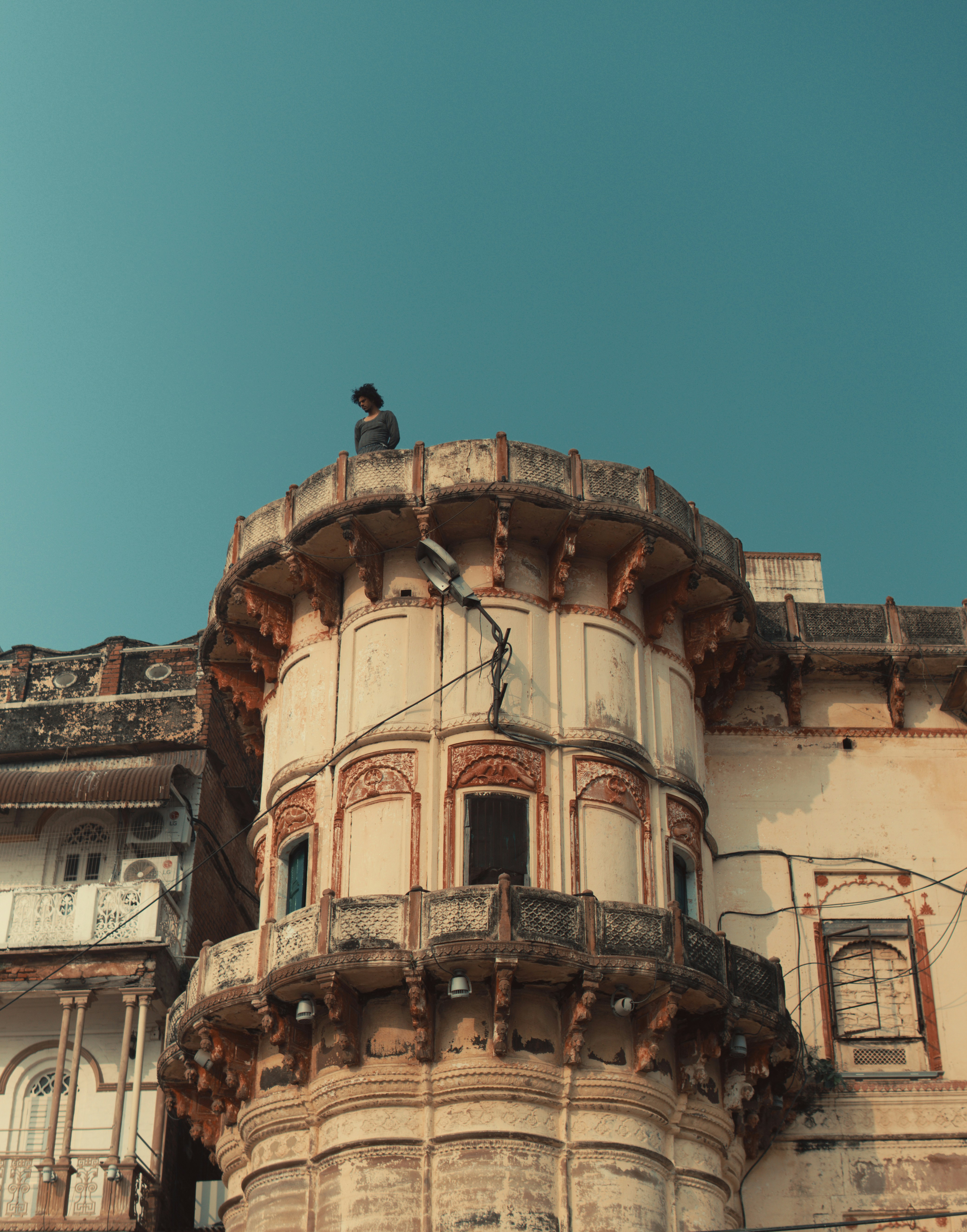 Watchtower Gaze: A solitary figure atop a weathered façade