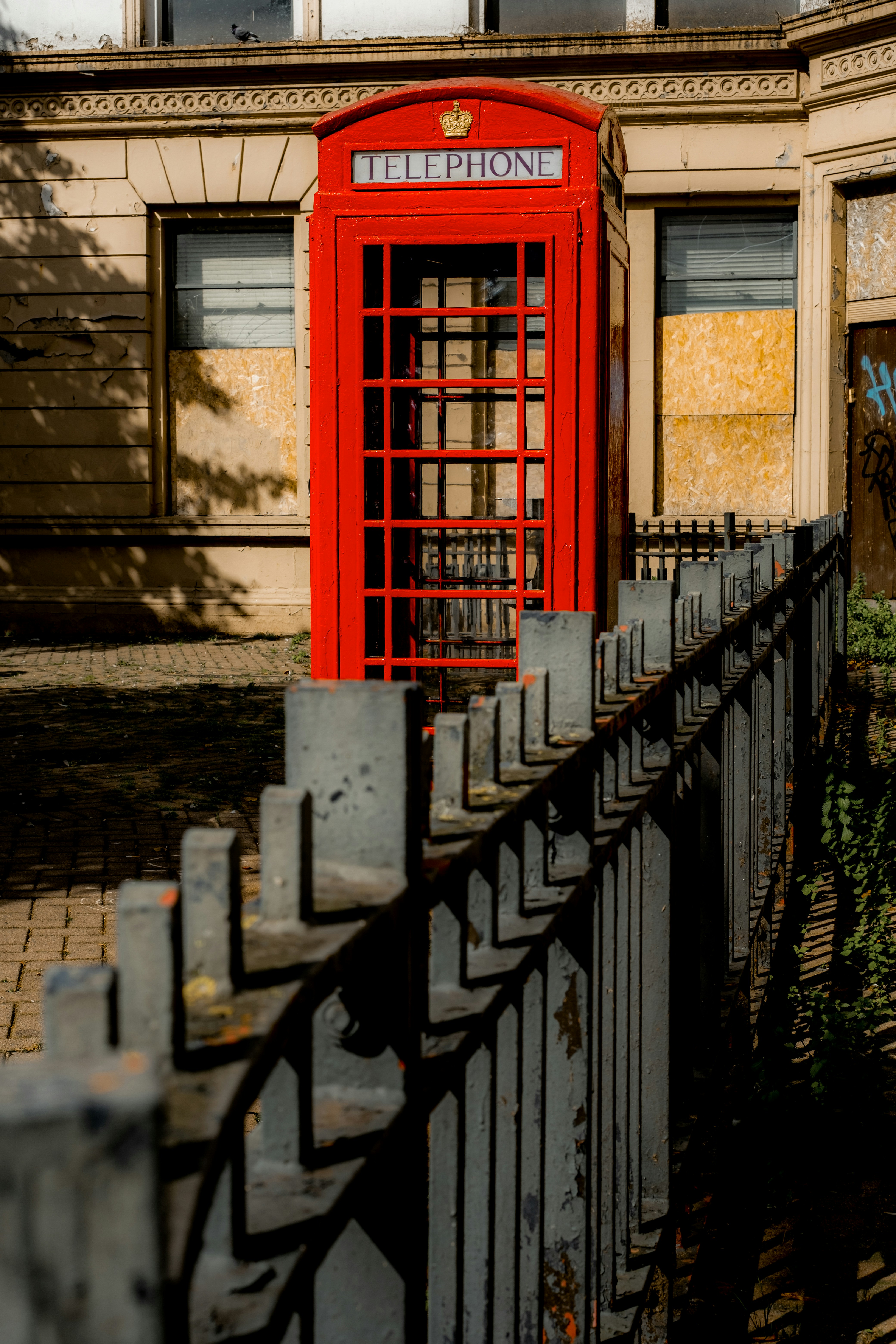 Red Telephone Guardian at the Edge of the Sidewalk