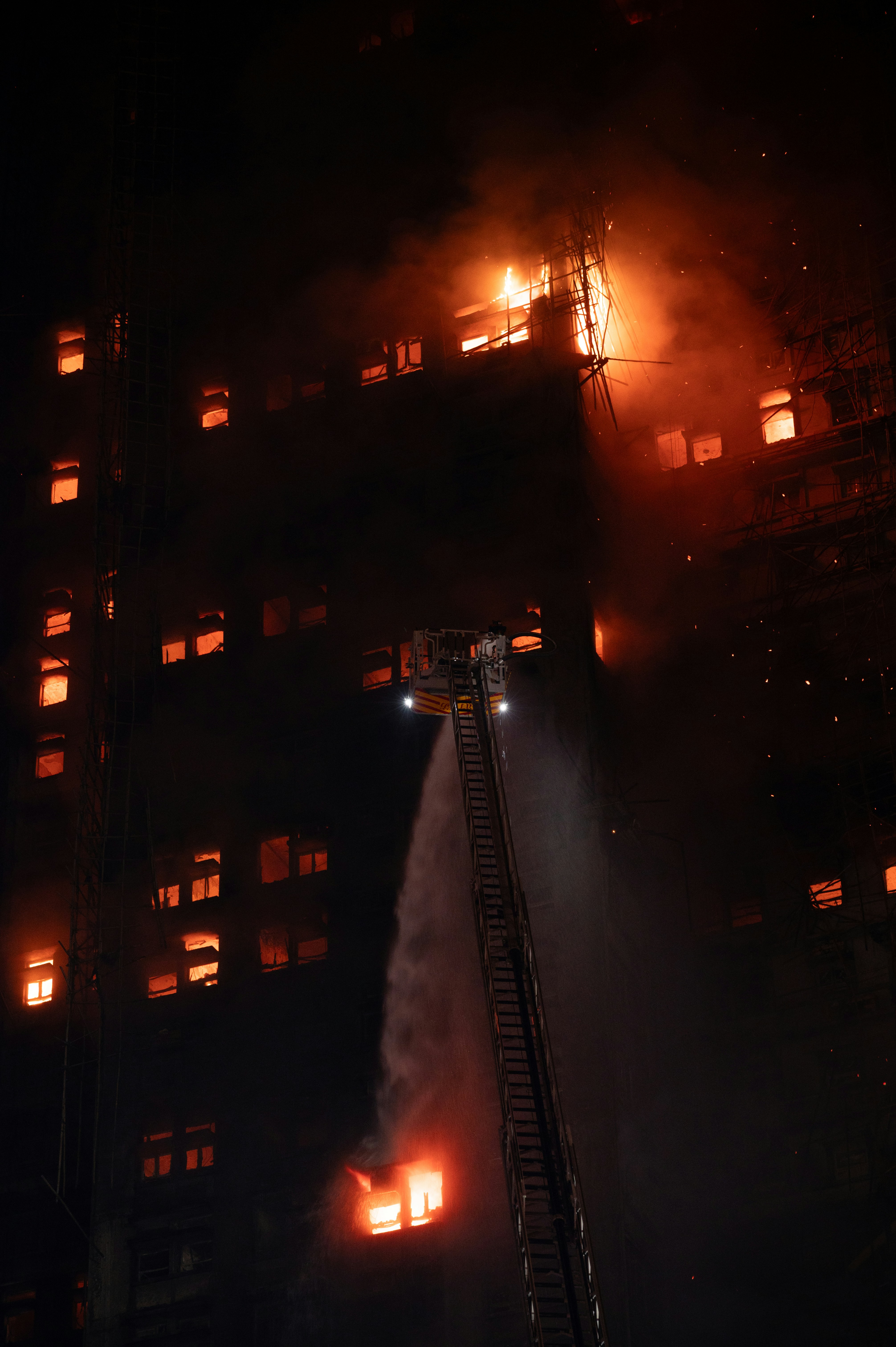 Rising Inferno: Fire climbs a skeletal skyscraper as a ladder stream cascades into the void
