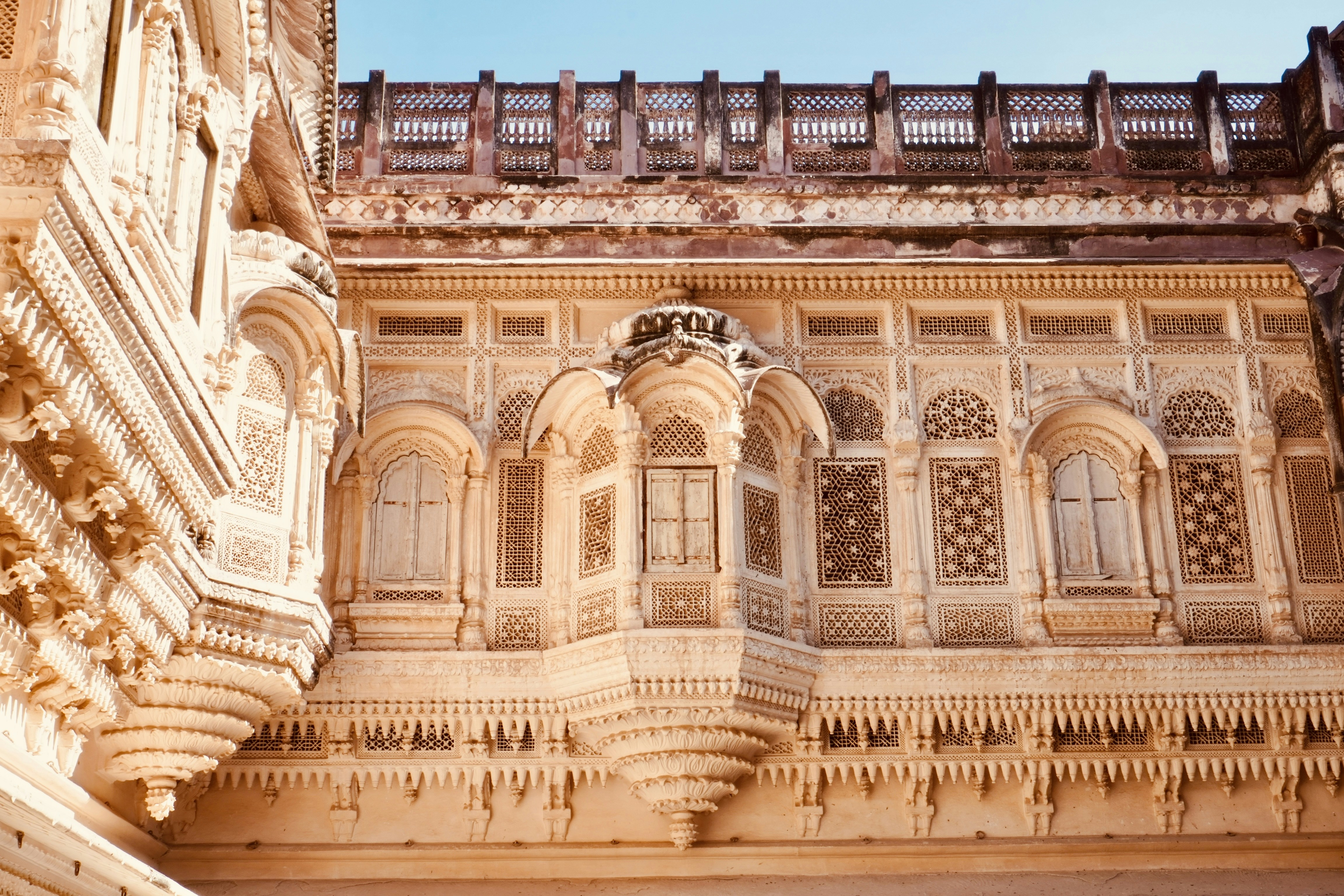 Mehrangarh Fort: a crimson colossus crowned above indigo Jodhpur. Sandstone burns amber at dawn, jharokhas drip molten gold, and the desert wind hums old war songs through silent corridors. Five centuries tall, it makes even gods look up. Below, the Blue City dreams; up here, time forgets to move. Timeless. Undefeated. Alive. 🏰✨