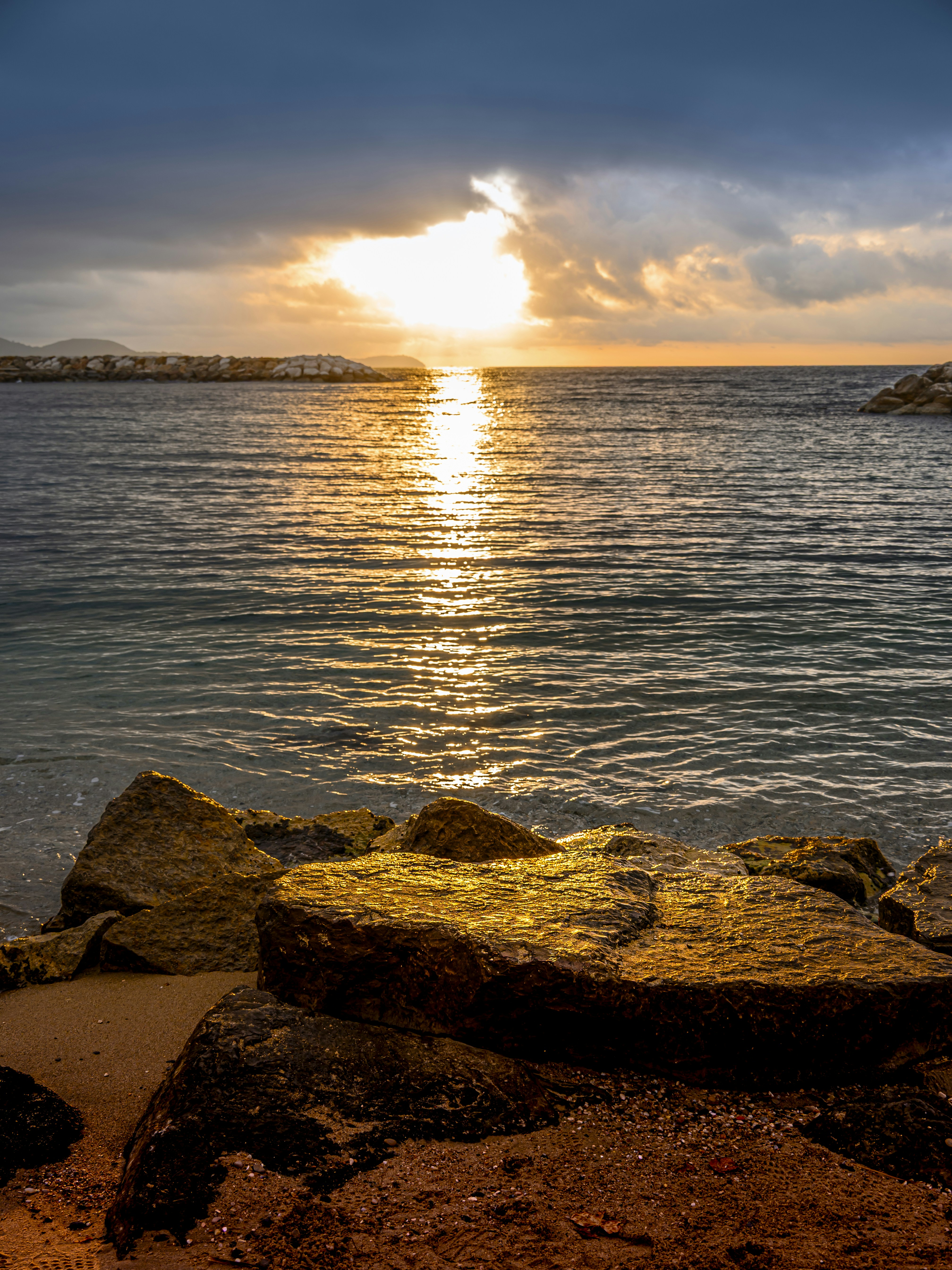 Sunlit Path: Golden Rocks Meet a Quiet Sea