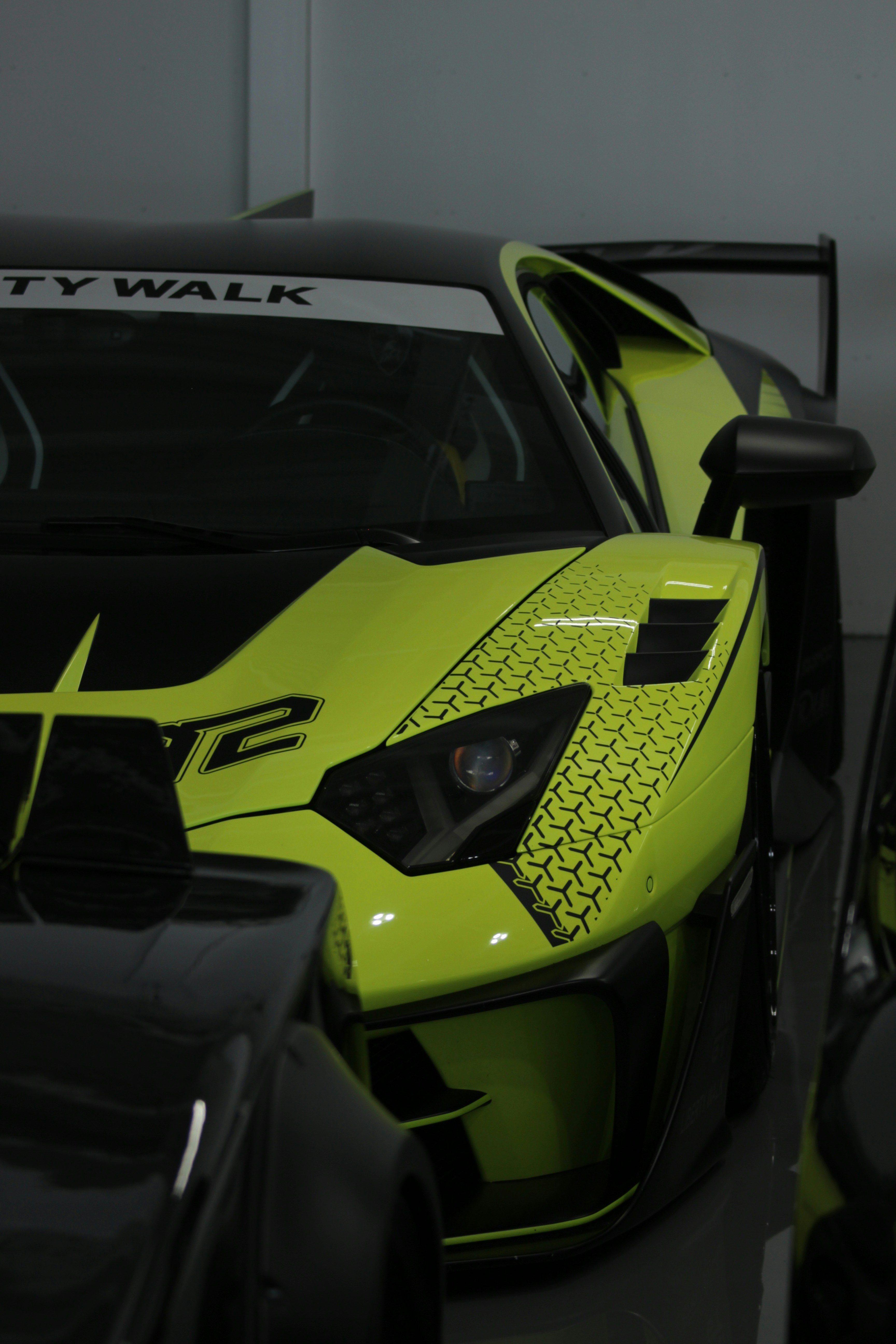 Neon-yellow racecraft: a close-up of the front fascia in a showroom harbor