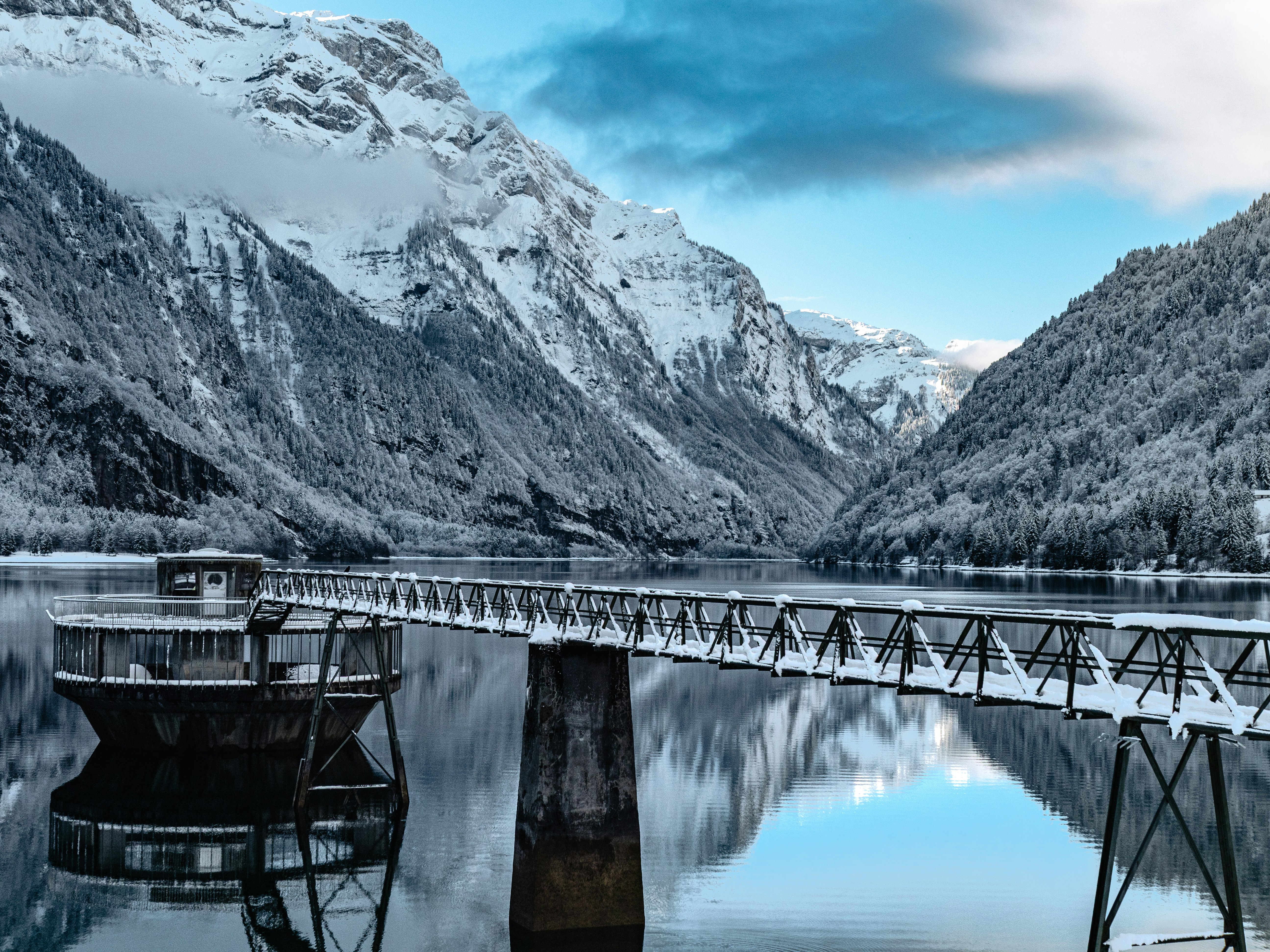 Snowbound Corridor: A Bridge Dips into Glassy Peaks