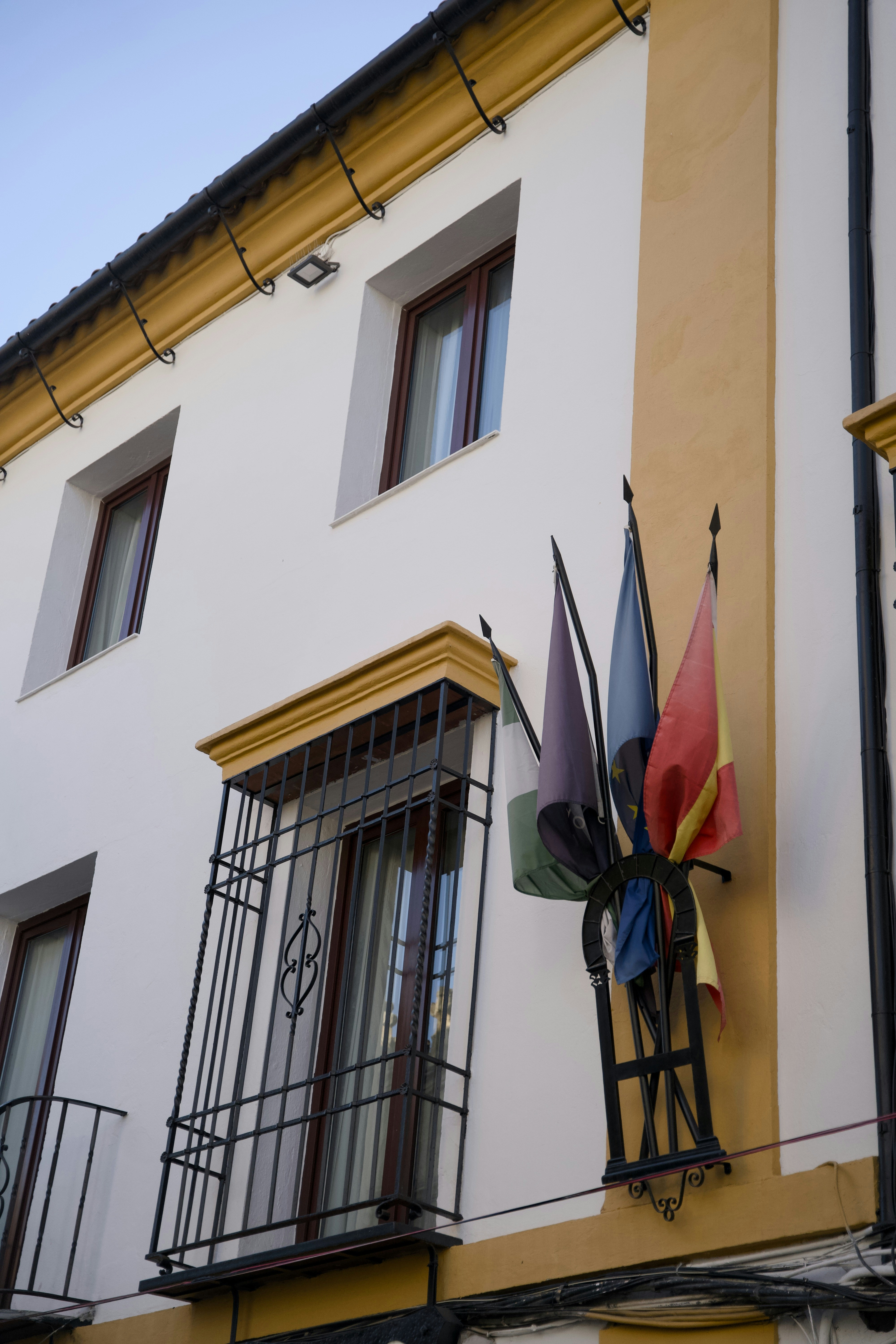 Flags at the Balcony: A Sunlit Spanish Street Corner
